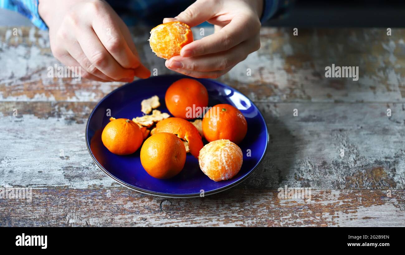 Hand peeling fresh orange fruit hi-res stock photography and images - Alamy