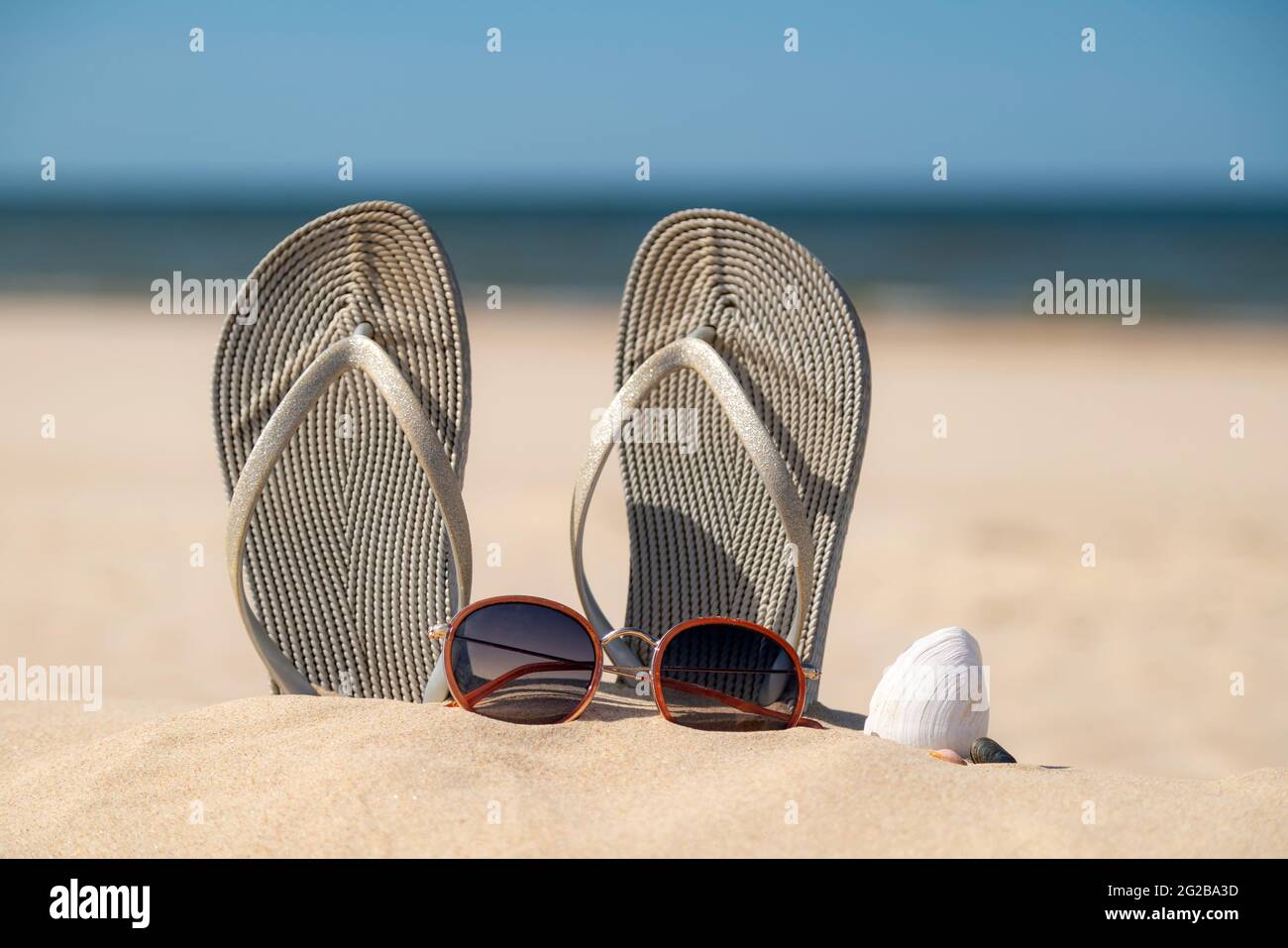 Grey sandals at the beach on a beautiful sunny day. Slippers in the ...