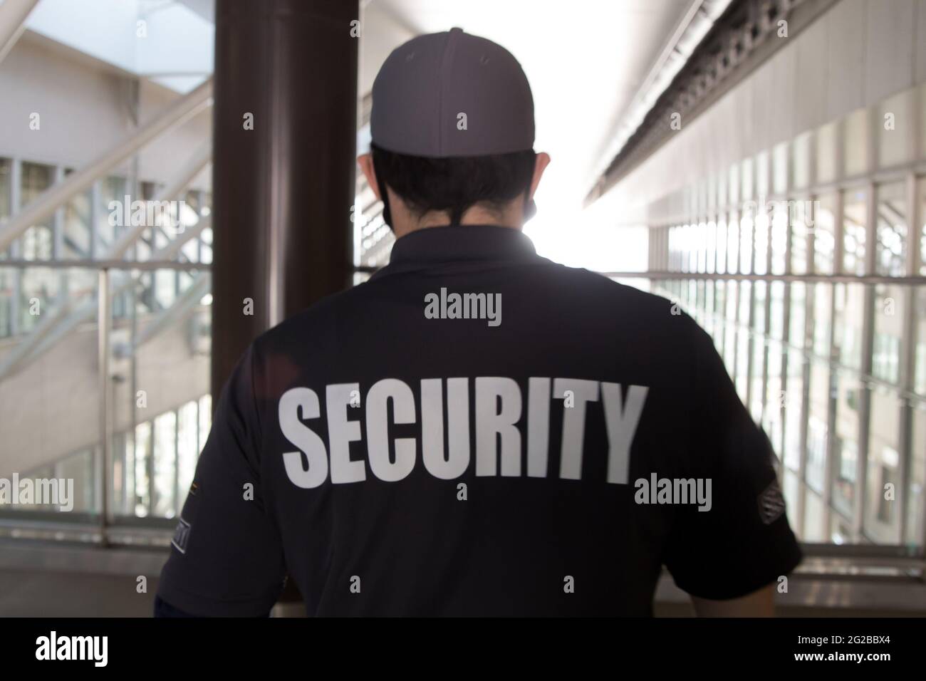 Security guard standing inside a commercial building Stock Photo - Alamy