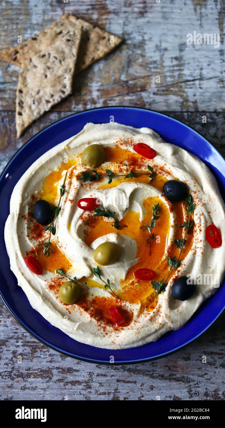 A plate of hummus. Healthy snack hummus with olives and paprika ...