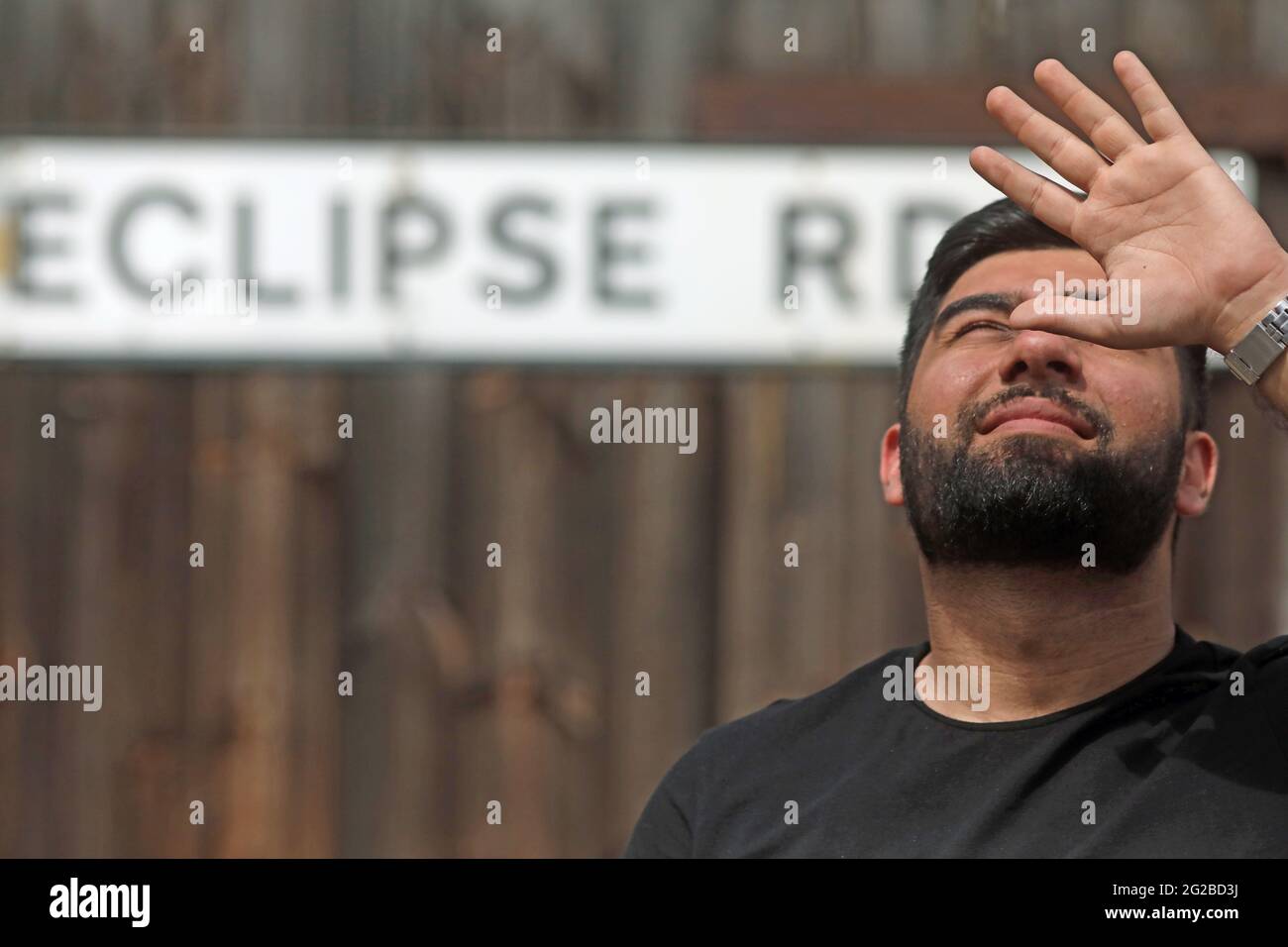 Hamza Qureshi looks towards the skies from Eclipse Road, in east London ...
