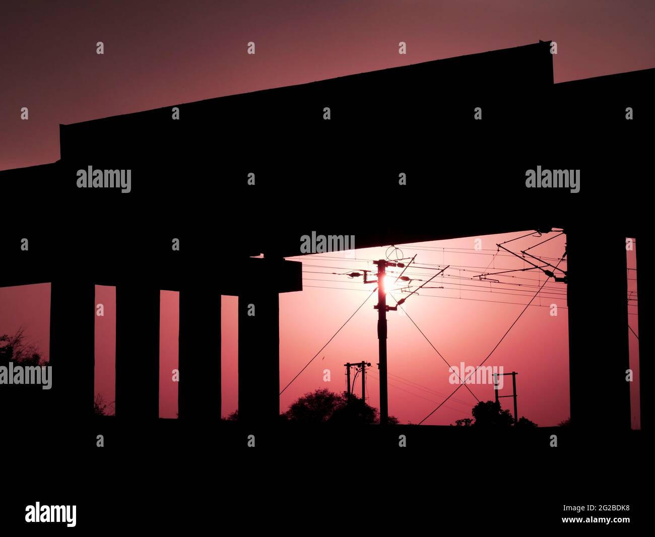 Pink sunset railway bridge silhouette with electricity transformer sun ...