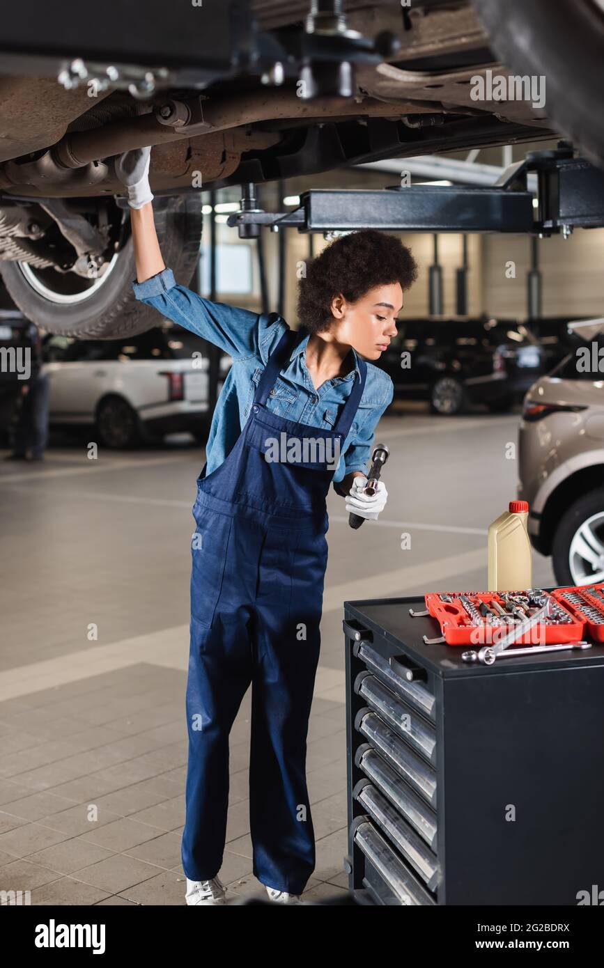 young african american mechanic working underneath car in garage Stock ...