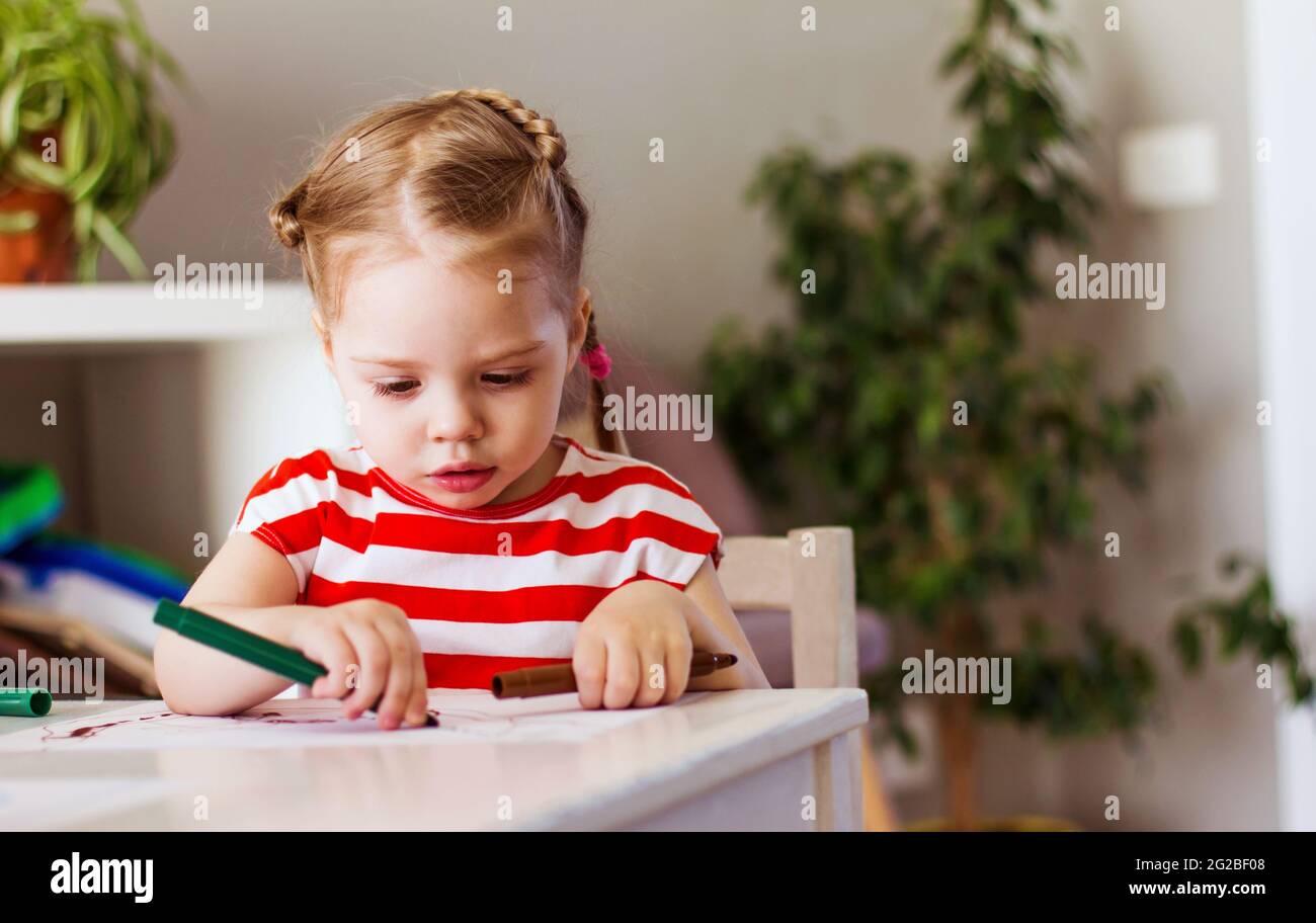 Little girl and boy children at home sit at the table and draw with ...