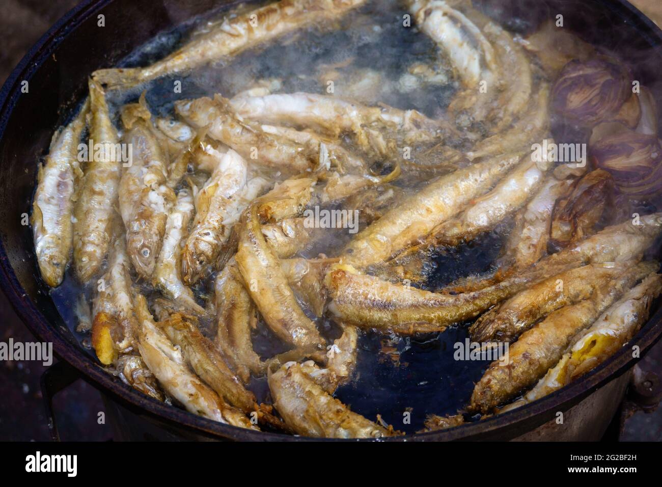 Fish frying in hot oil Stock Photo - Alamy