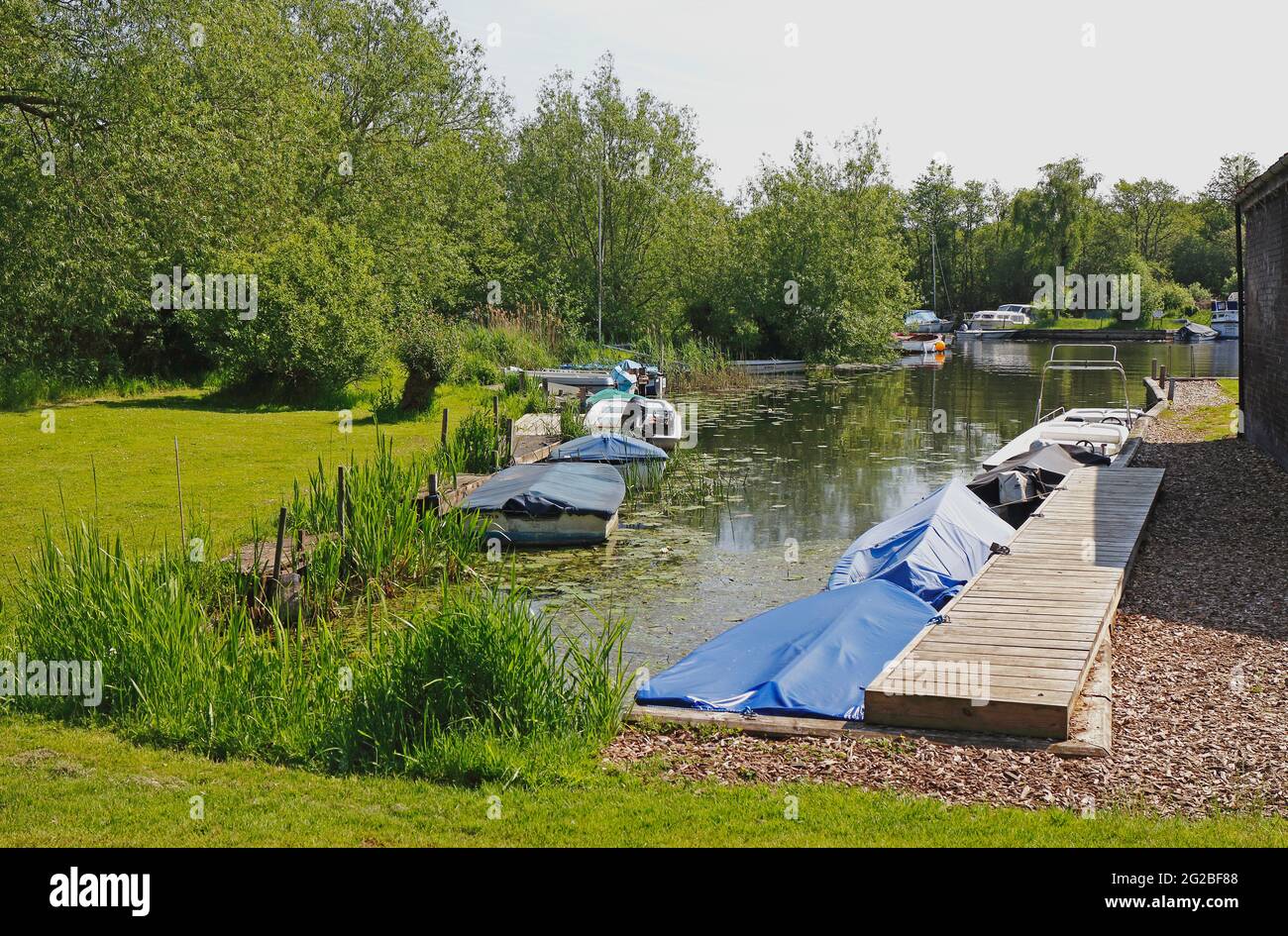 A view of a dyke with moored small boats on the Norfolk Broads at ...
