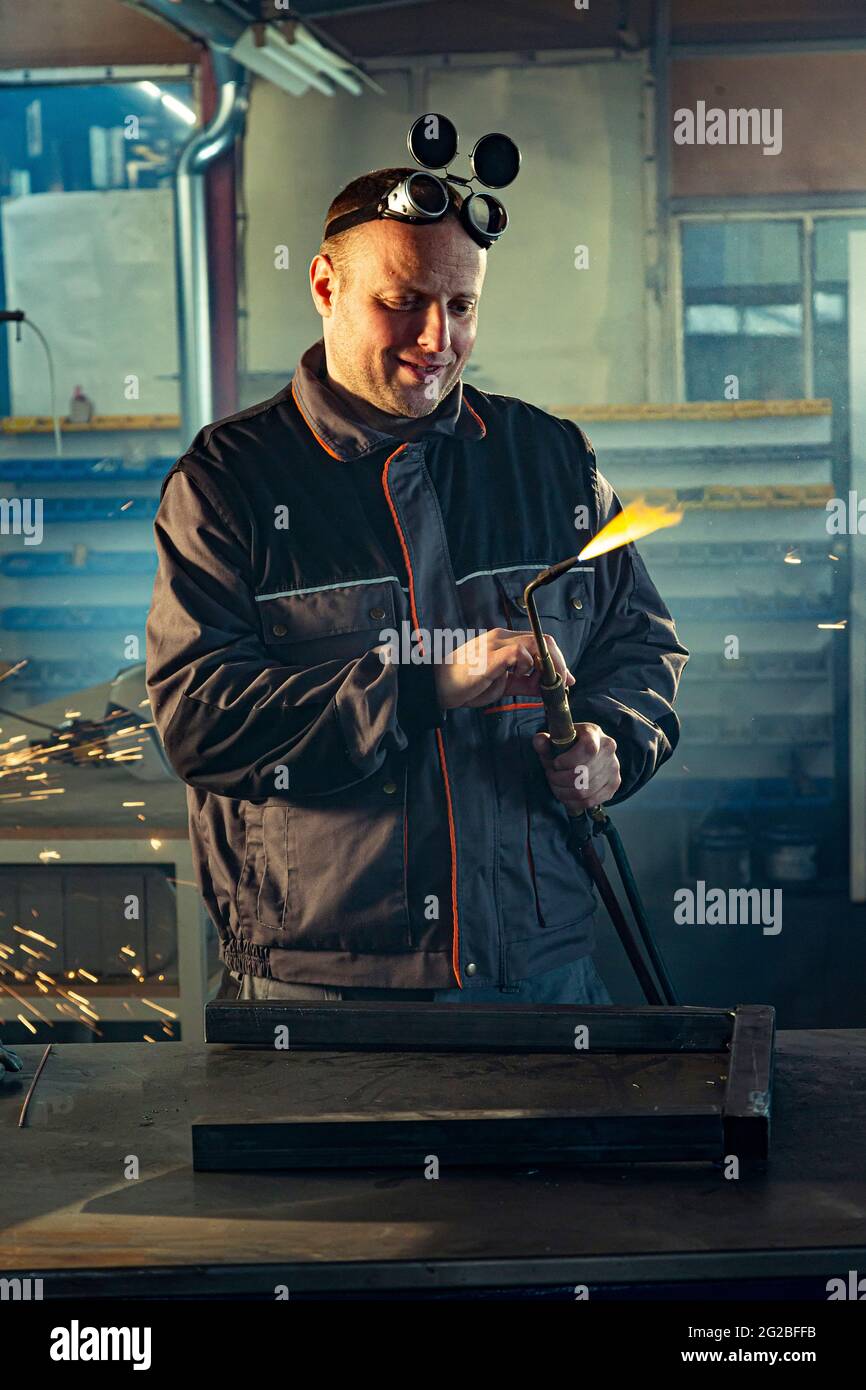 Handyman preparing his autogenous welding tool for work while his ...