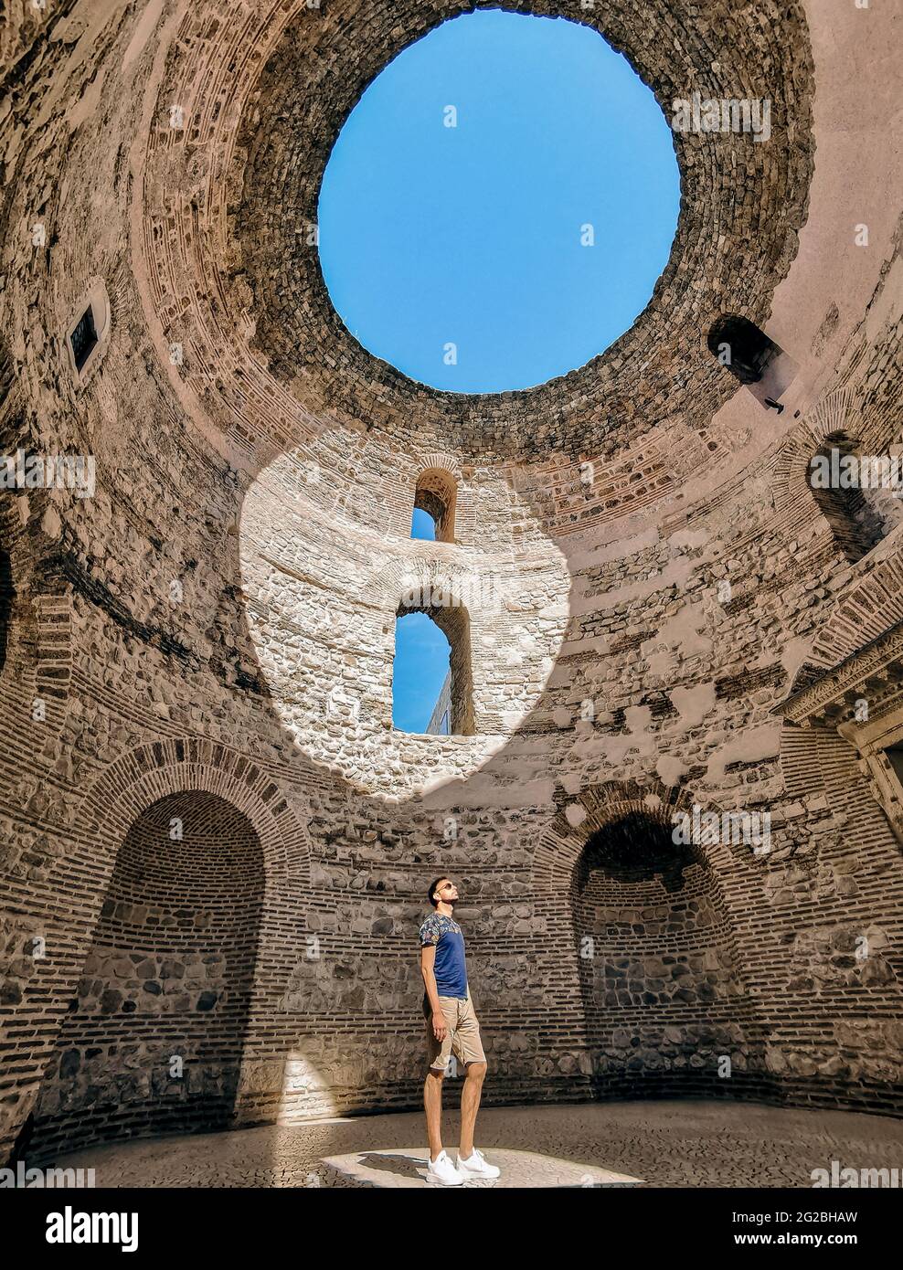 Man standing inside ancient roman building with natural light shining ...