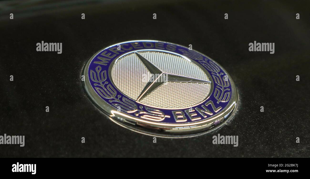 Close-up of the blue circular Mercedes Benz logo on the hood of a black ...