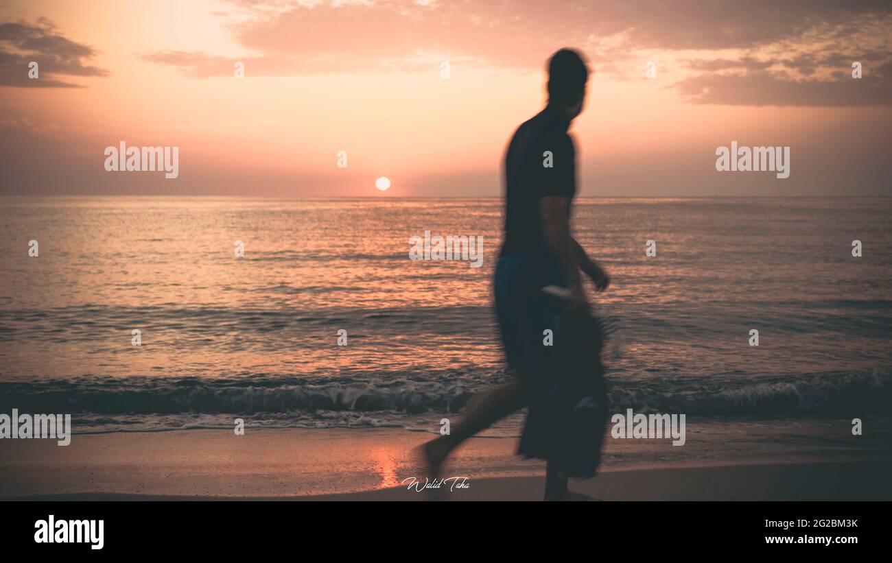 Surfer Walking Along The Beach Near Burj Al Arab Hotel Hi Res Stock