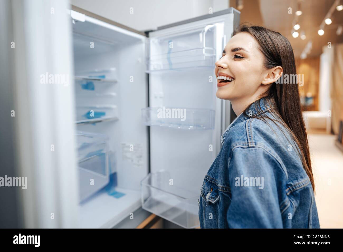 Young attractive woman choosing refrigerator in hypermarket Stock Photo ...