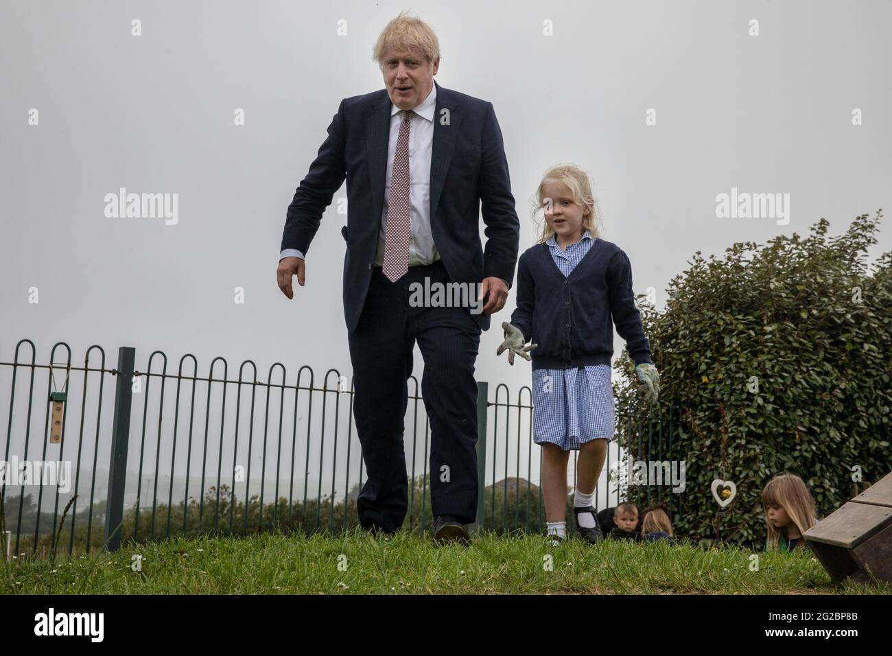 Prime Minister Boris Johnson is guided by Beatrix Collins, 7, through ...