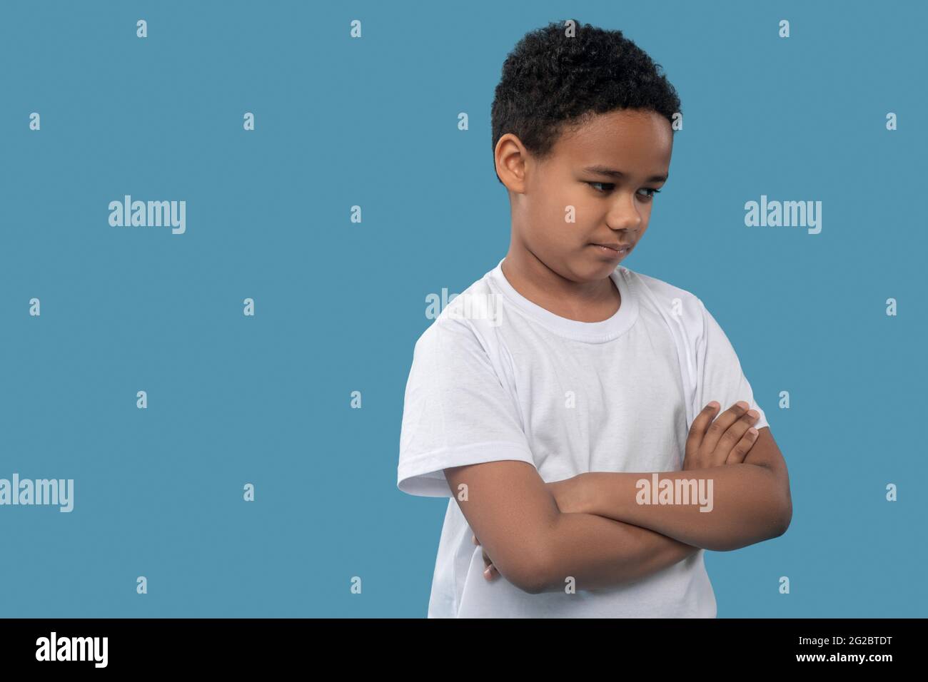 Sad boy folded arms across his chest Stock Photo - Alamy