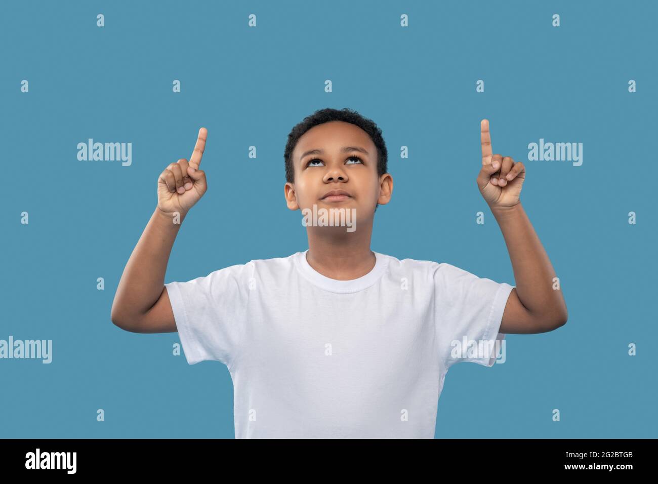 Boy looking and pointing finger up Stock Photo - Alamy