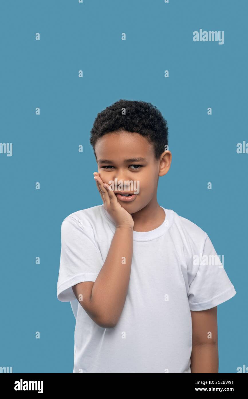 Sad african american boy holding cheek Stock Photo - Alamy
