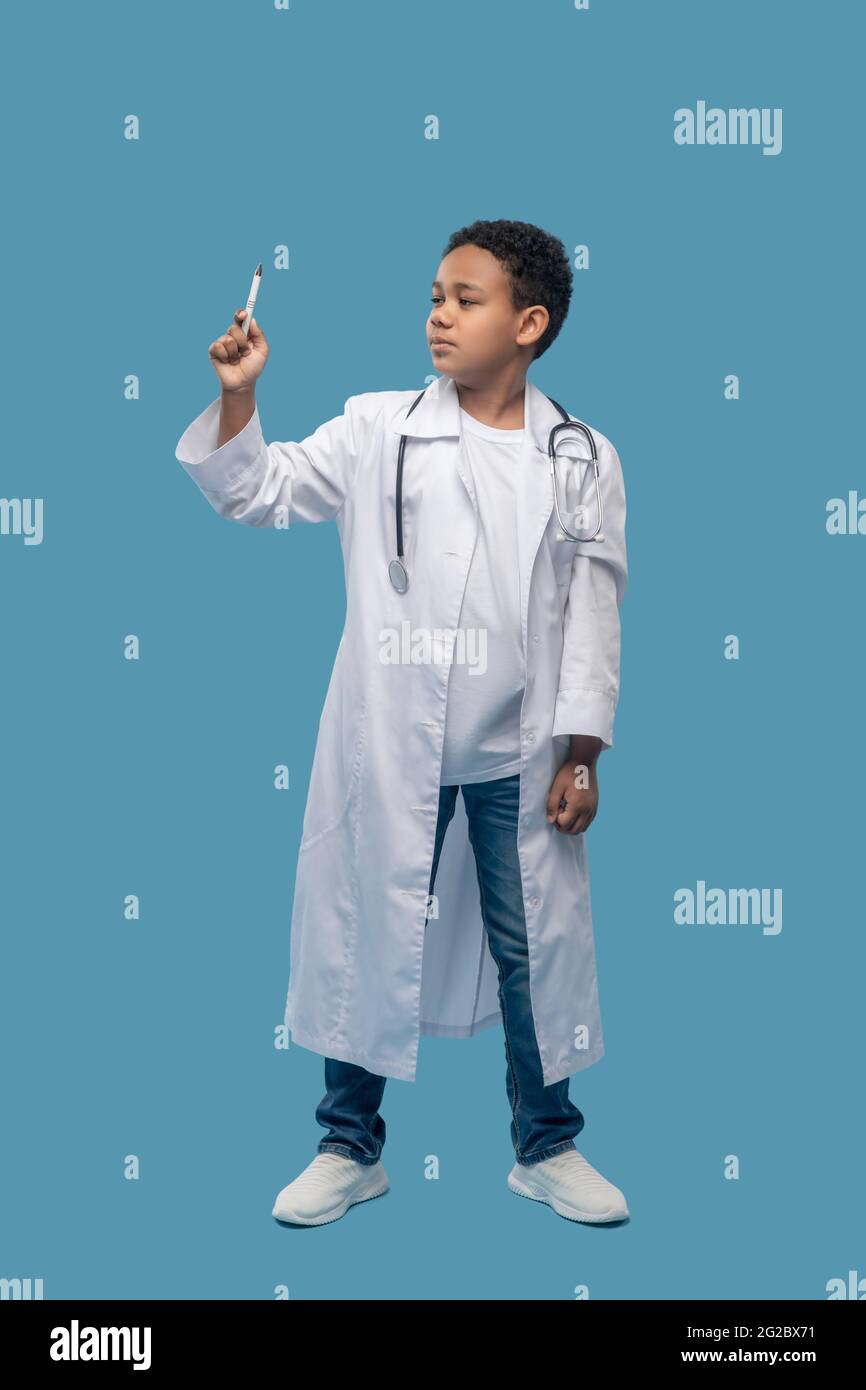 Boy in lab coat following pointer with his eyes Stock Photo - Alamy