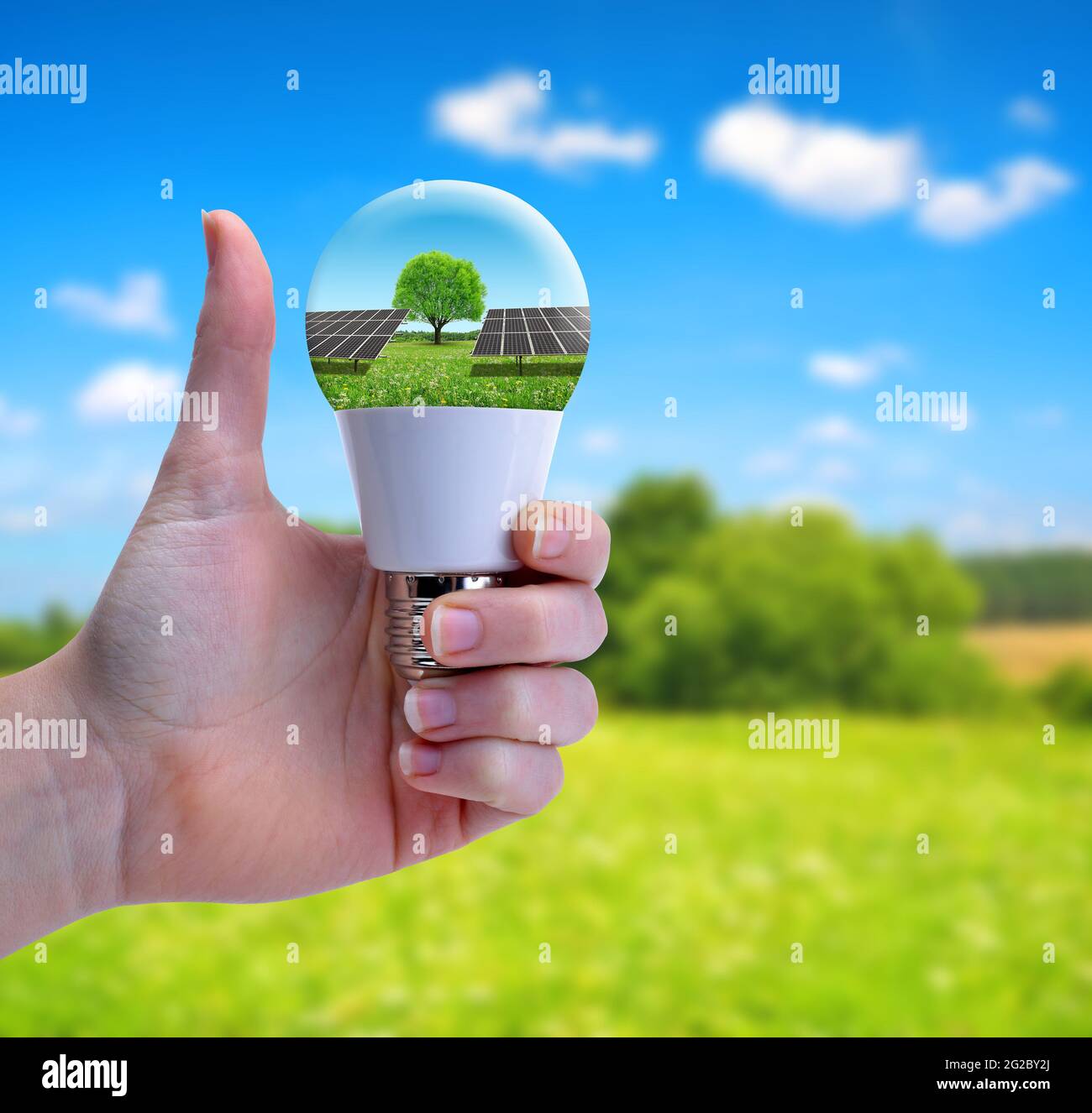 Hand with thumb up holding a eco LED bulb with solar panel. The concept ...