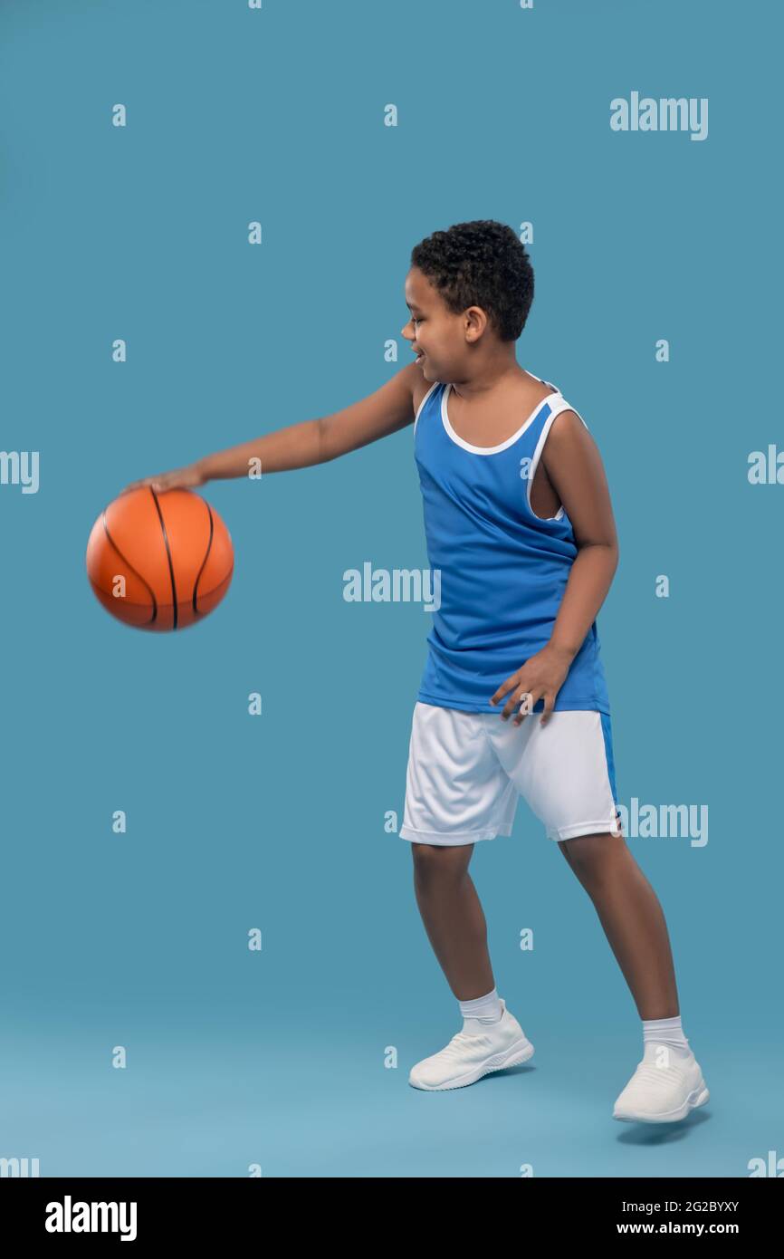 Boy in sportswear moving with ball in basketball Stock Photo - Alamy