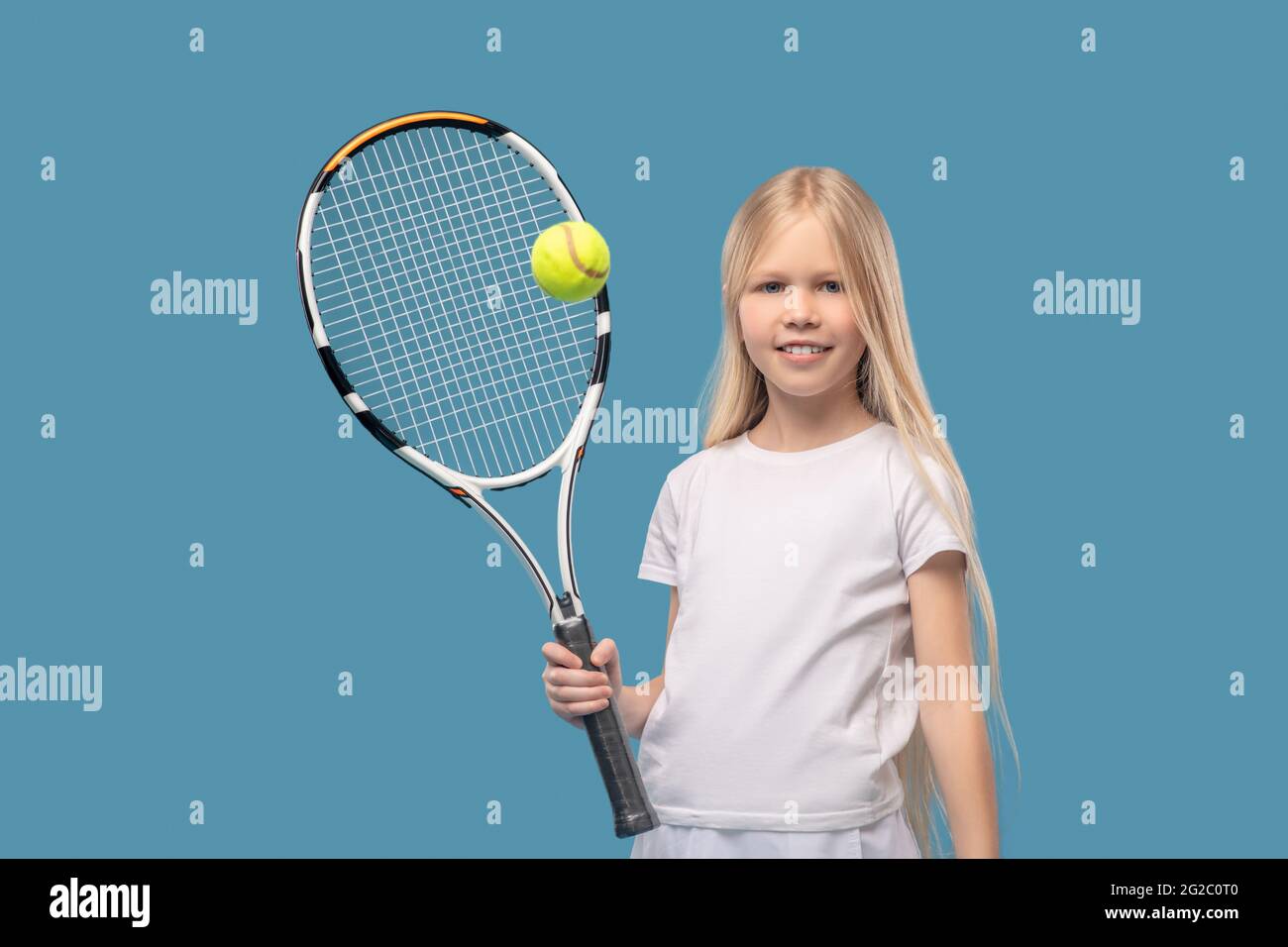 Happy teen tennis player hitting ball with racket Stock Photo - Alamy