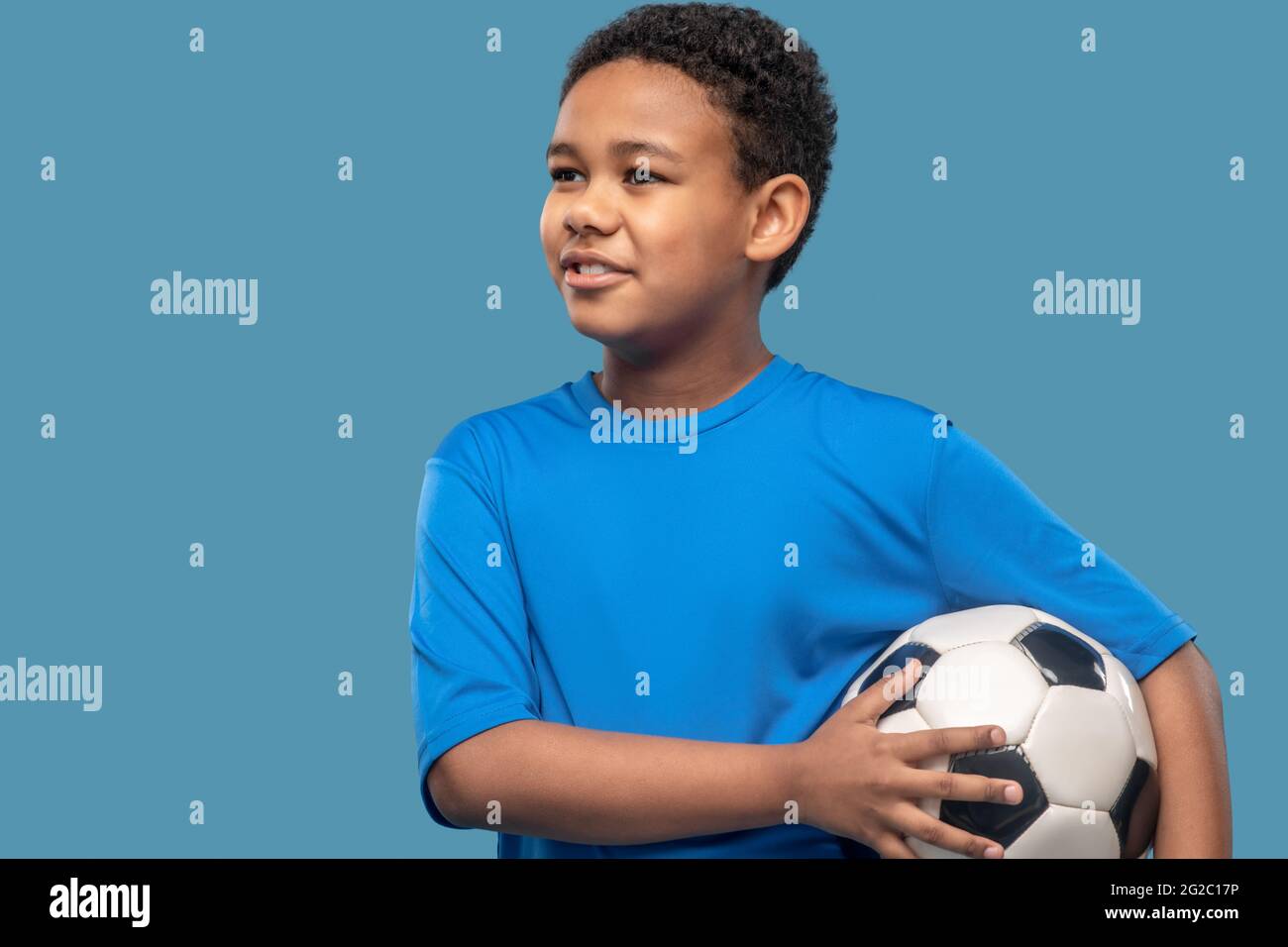 Joyful interested boy holding soccer ball Stock Photo - Alamy