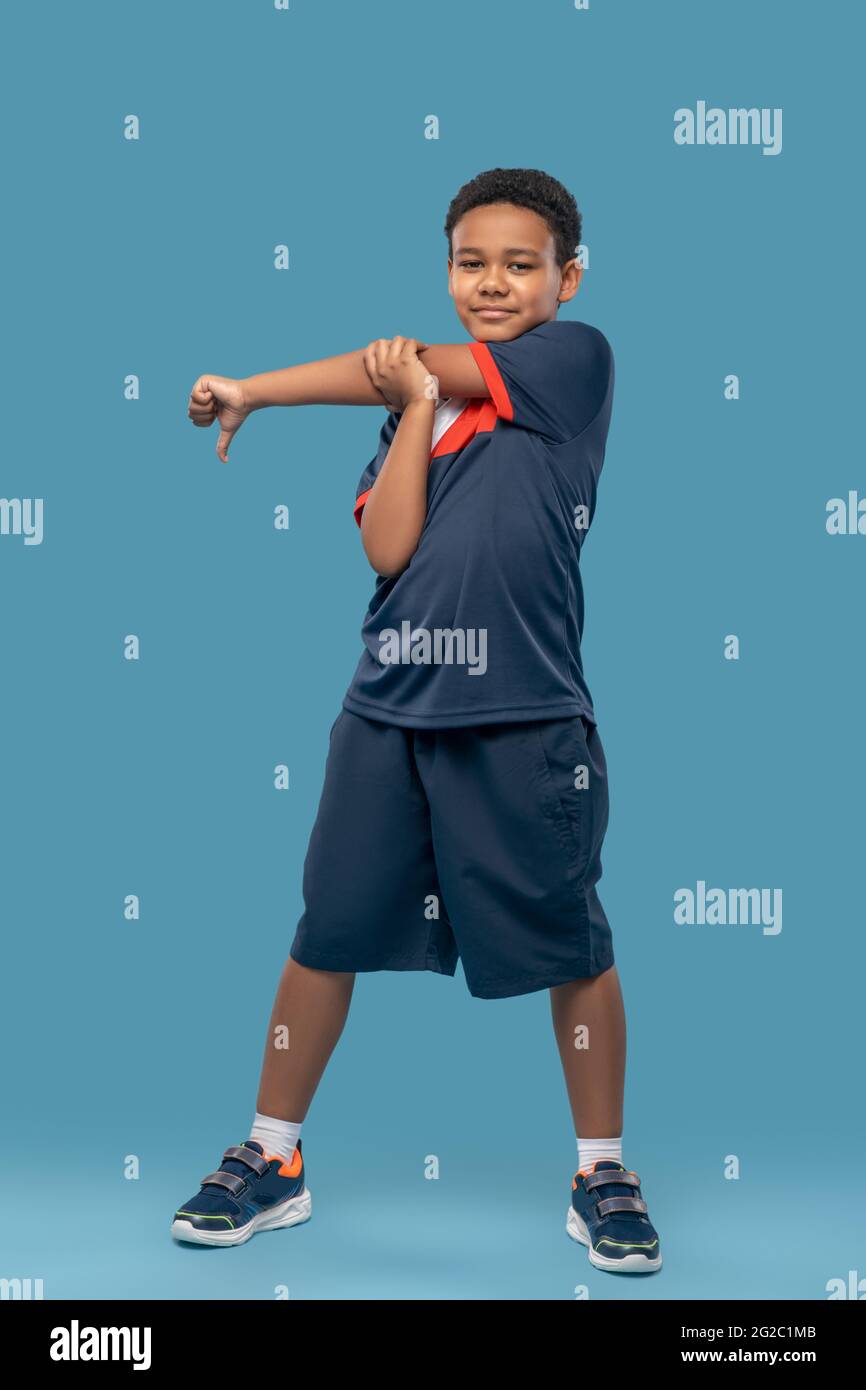 Smiling boy standing doing hand workout Stock Photo - Alamy