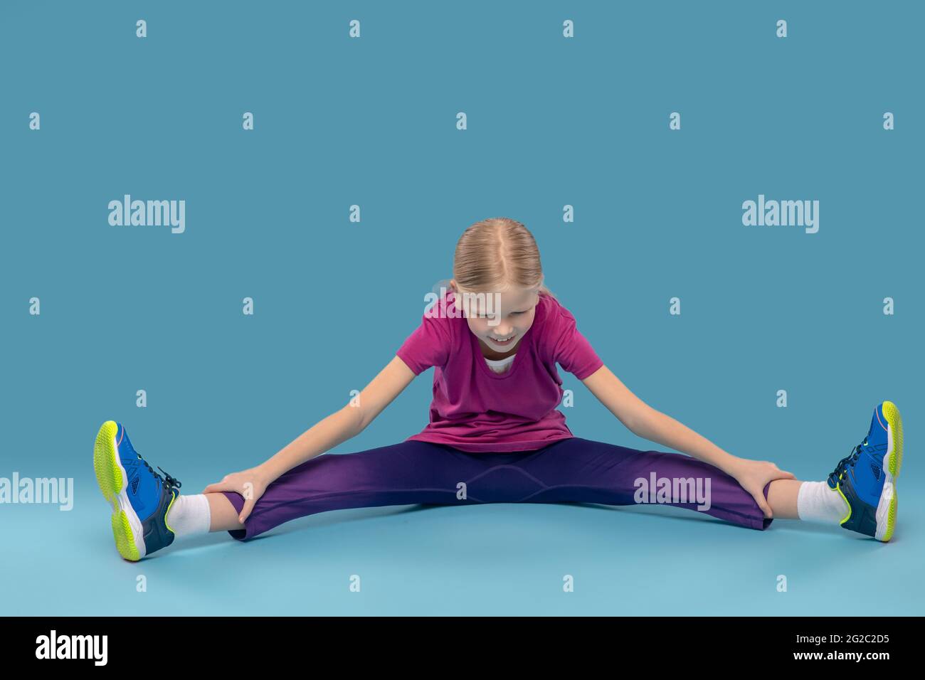 Girl on floor doing stretching exercise Stock Photo - Alamy