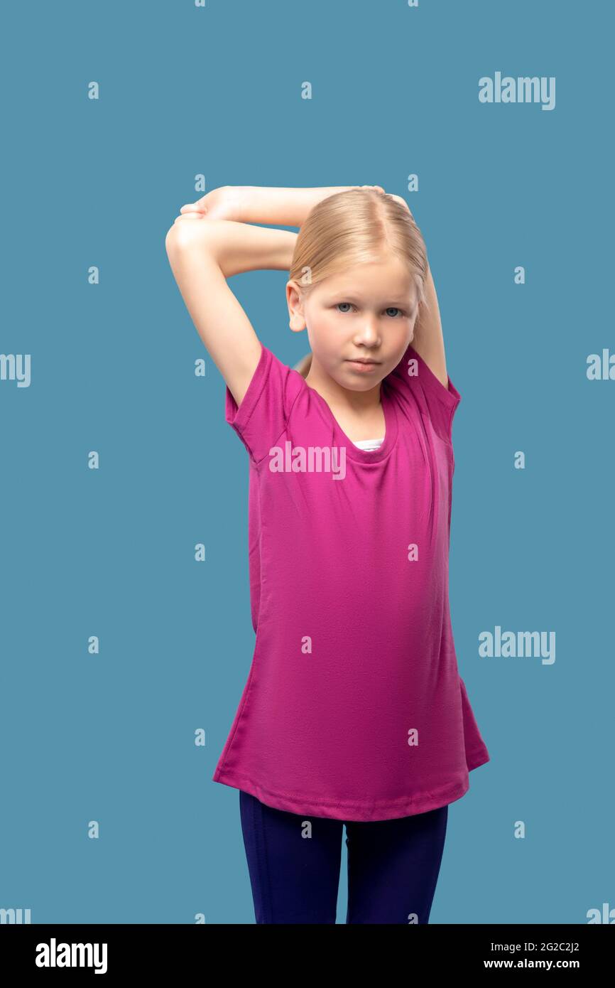 Focused girl doing arm stretching exercise Stock Photo - Alamy