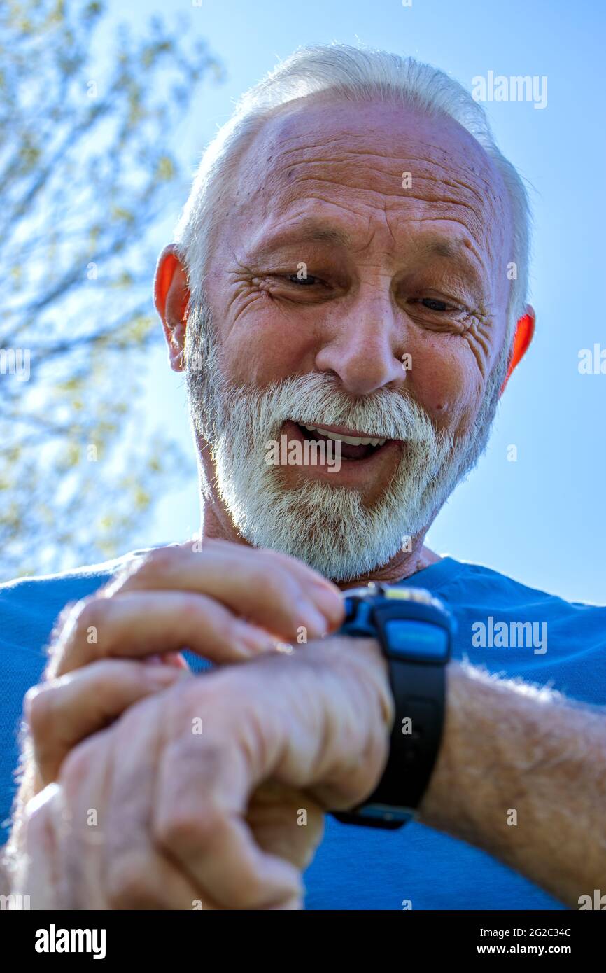 Portrait of a senior man checking his watch.The elderly sportsman ...