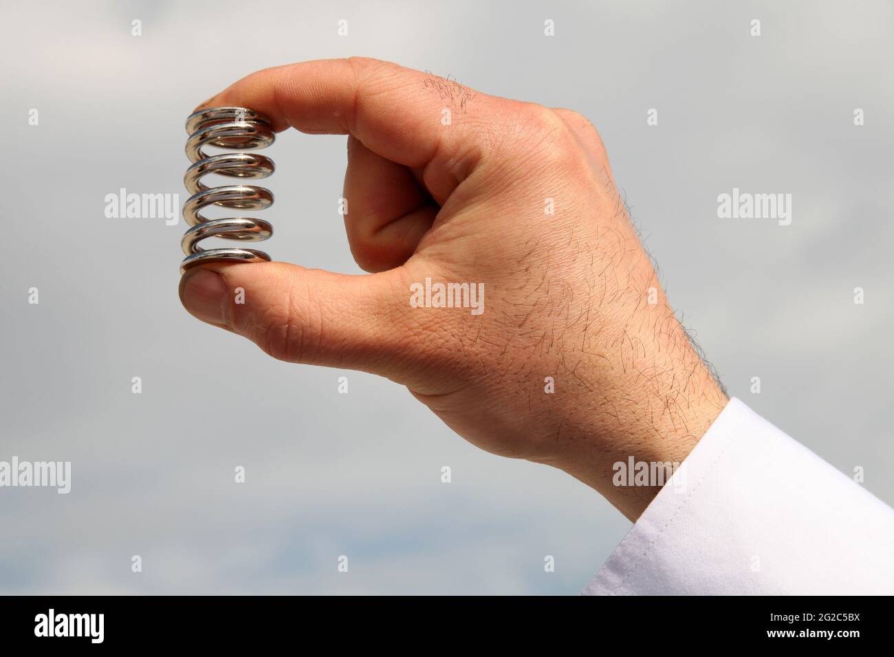 Metal spring in the hands of the engineer. Newly manufactured metal ...