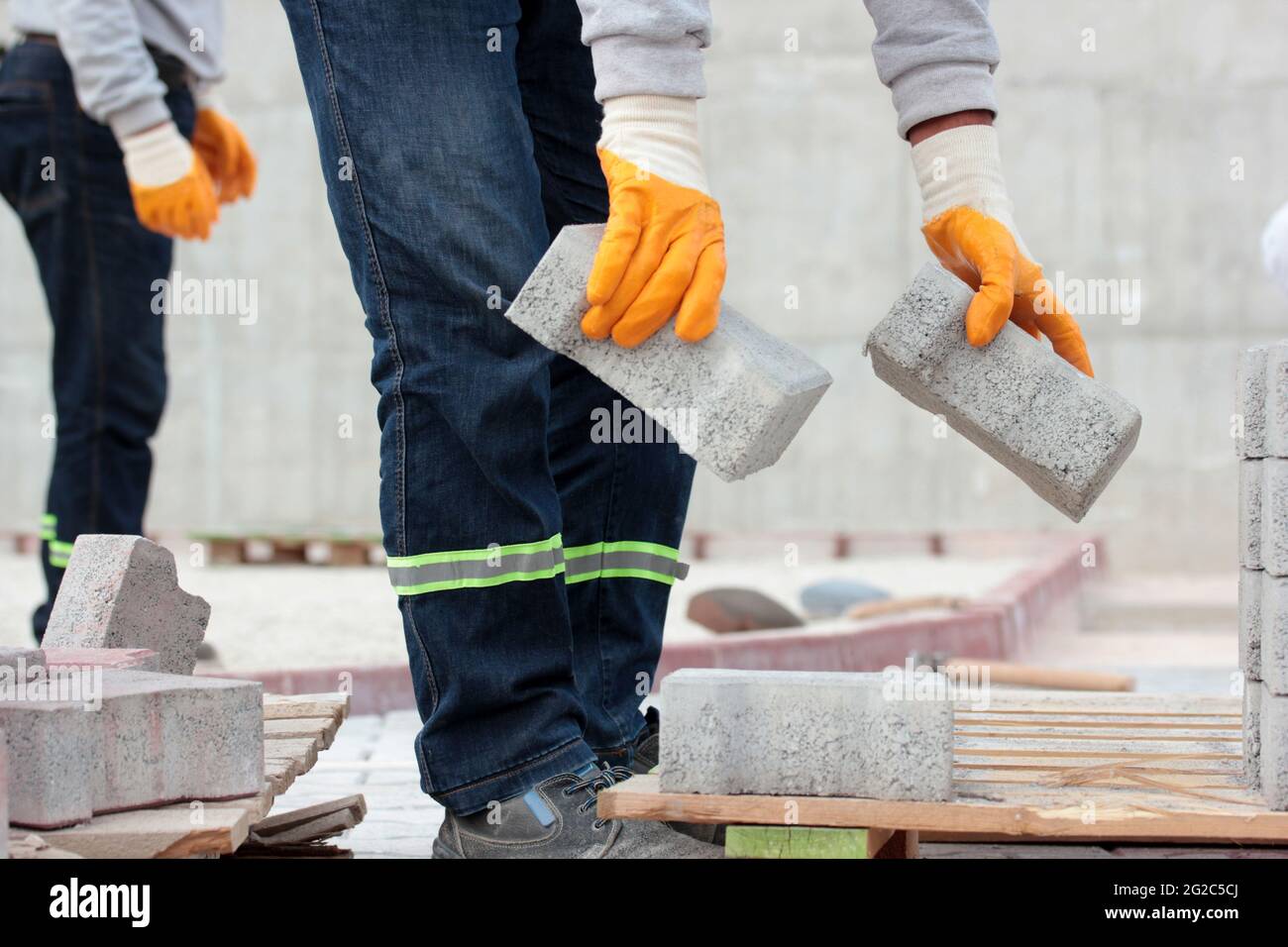 Paving stone worker is putting down pavers during a construction of a ...