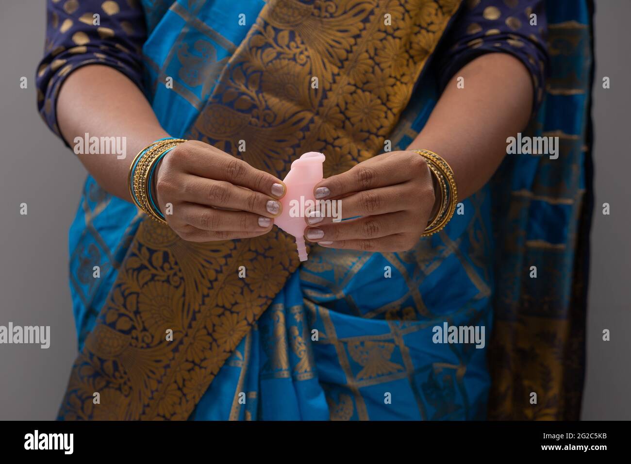 An Indian woman hand holding reusable silicon Menstrualcup and showing ...