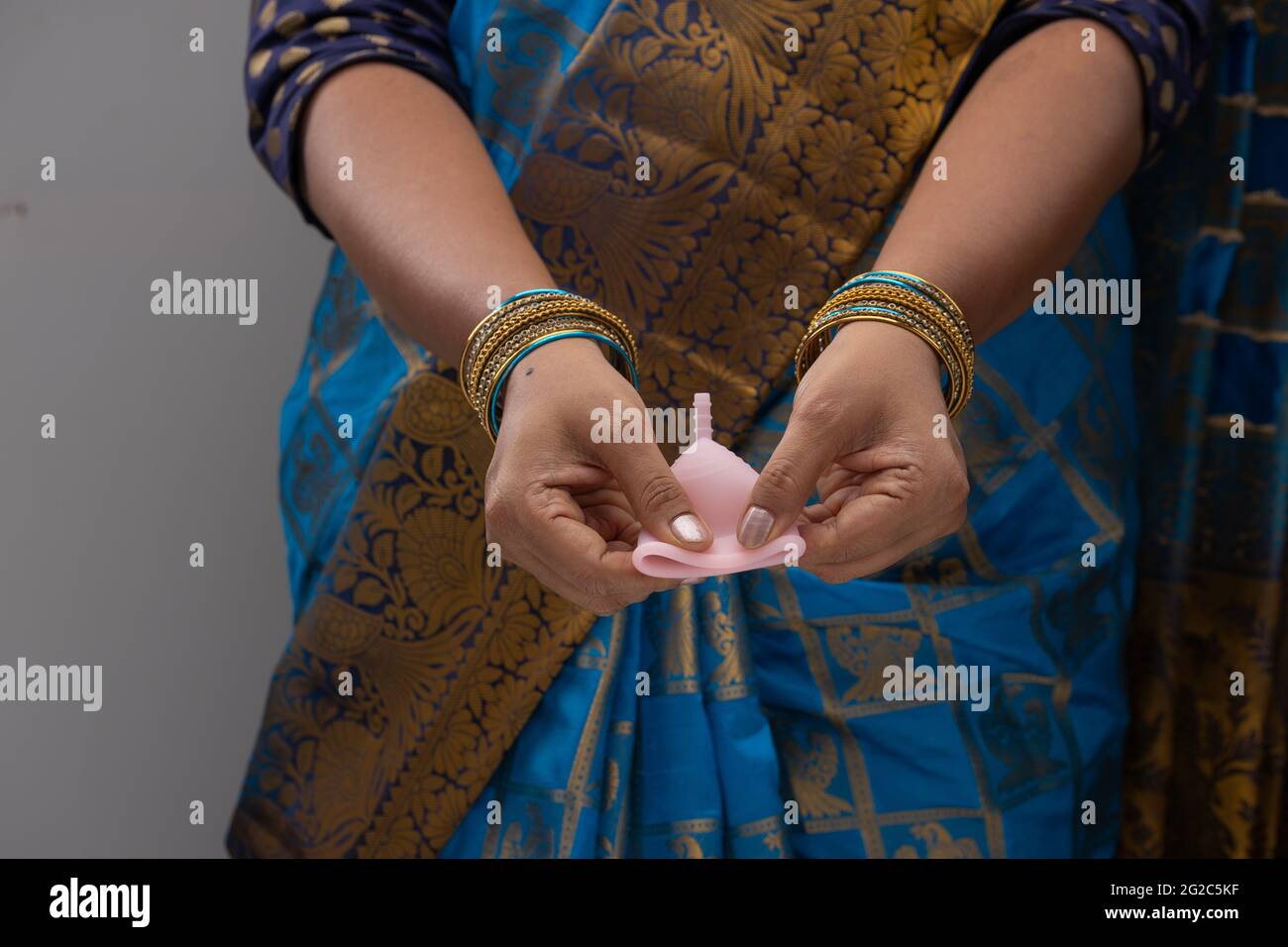 An Indian woman hand holding reusable silicon Menstrualcup and showing ...