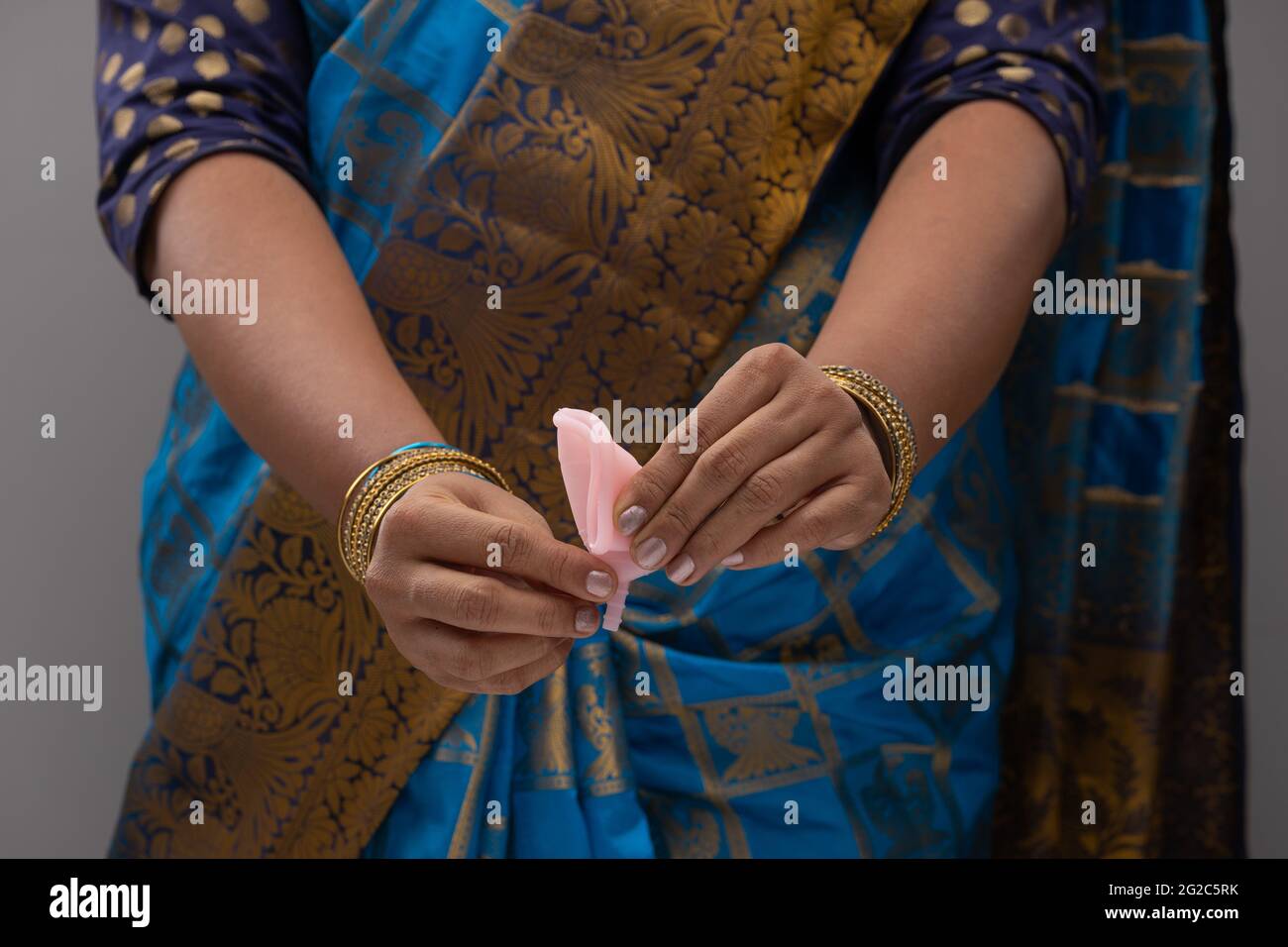 An Indian woman hand holding reusable silicon Menstrualcup and showing ...