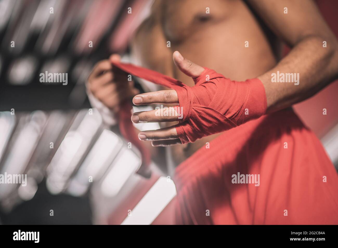 African american kickboxer typing a bandage on his hand before the ...