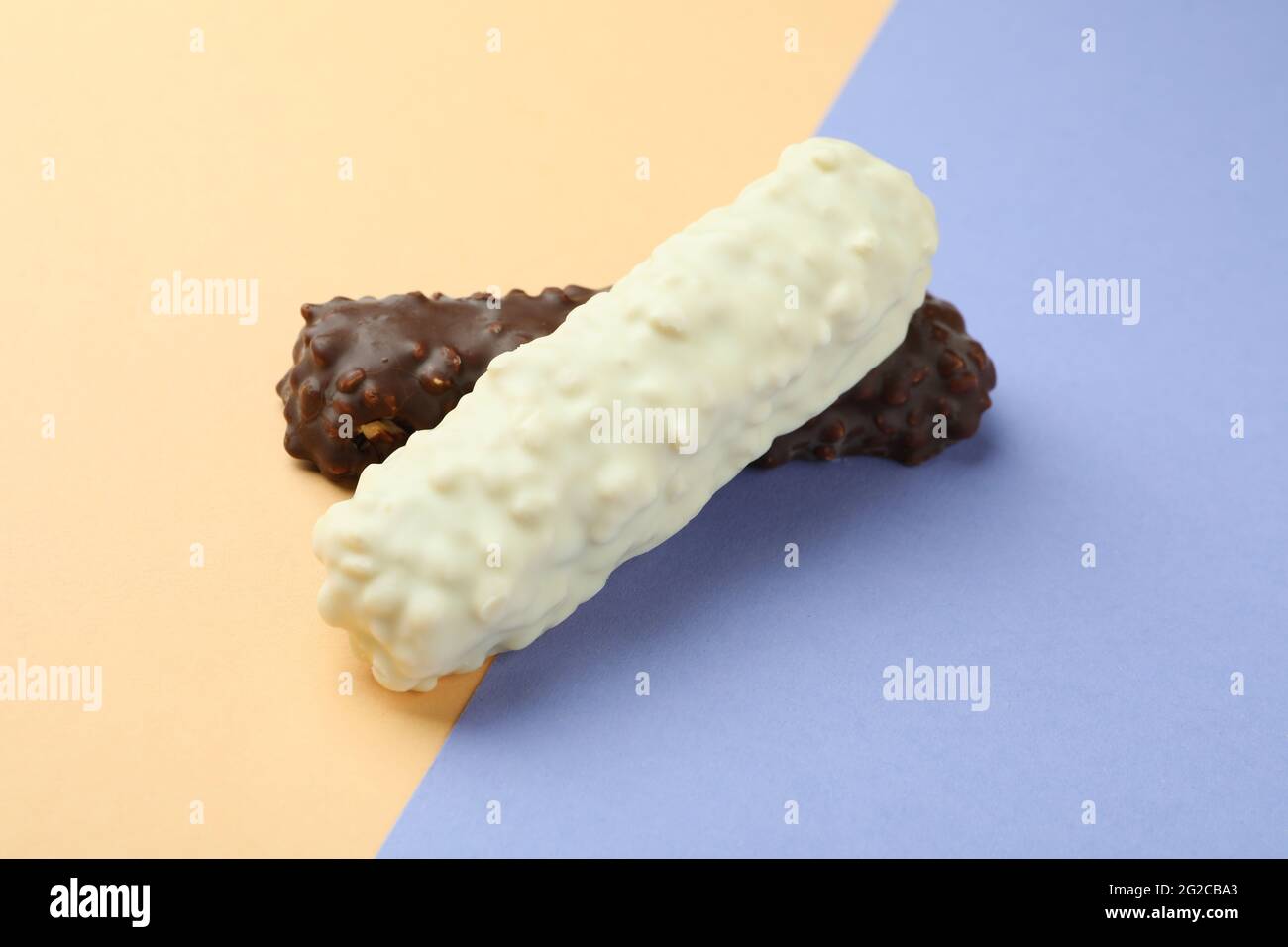 Tasty candy bars on two tone background Stock Photo - Alamy