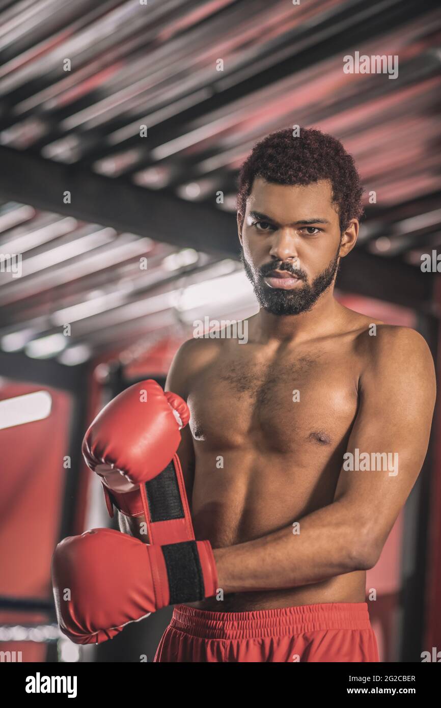 Dark-skinned kickboxer in red shorts and red boxing gloves Stock Photo ...