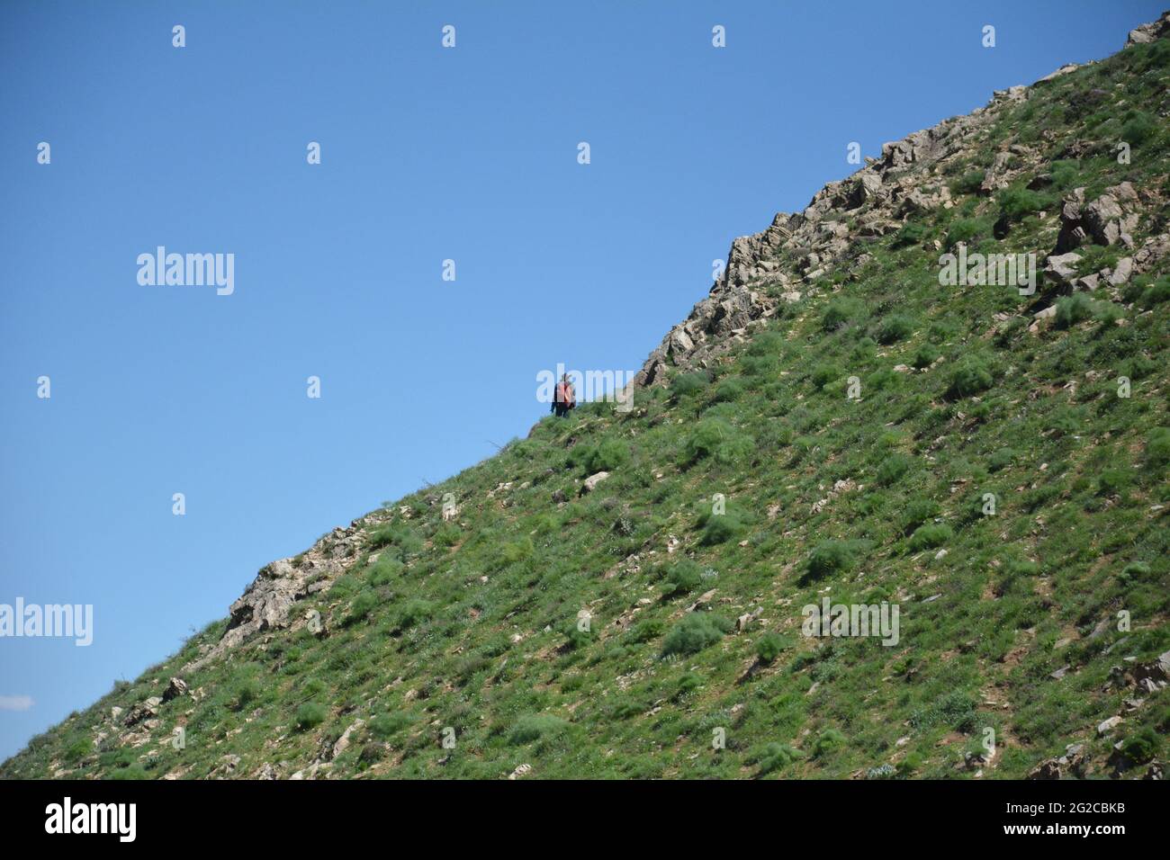 a man climbing mountain on hillside Stock Photo - Alamy