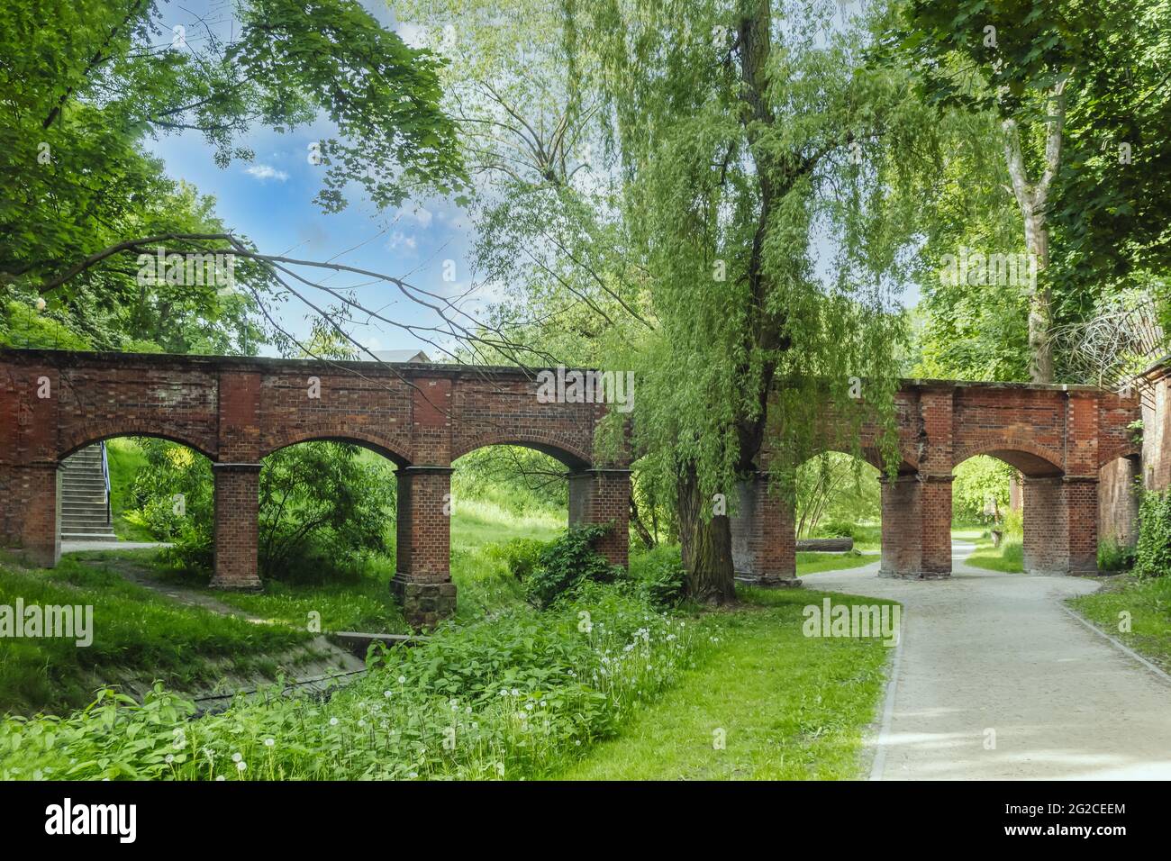 An arched red stone bridge in an old castle. View of the bridge with an ...