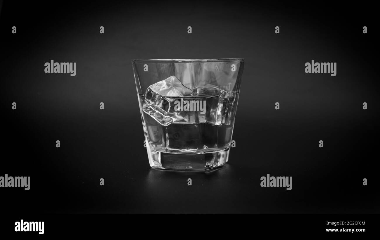 Whiskey, in a glass, full of cold, sparkling ice cubes. Black and white ...
