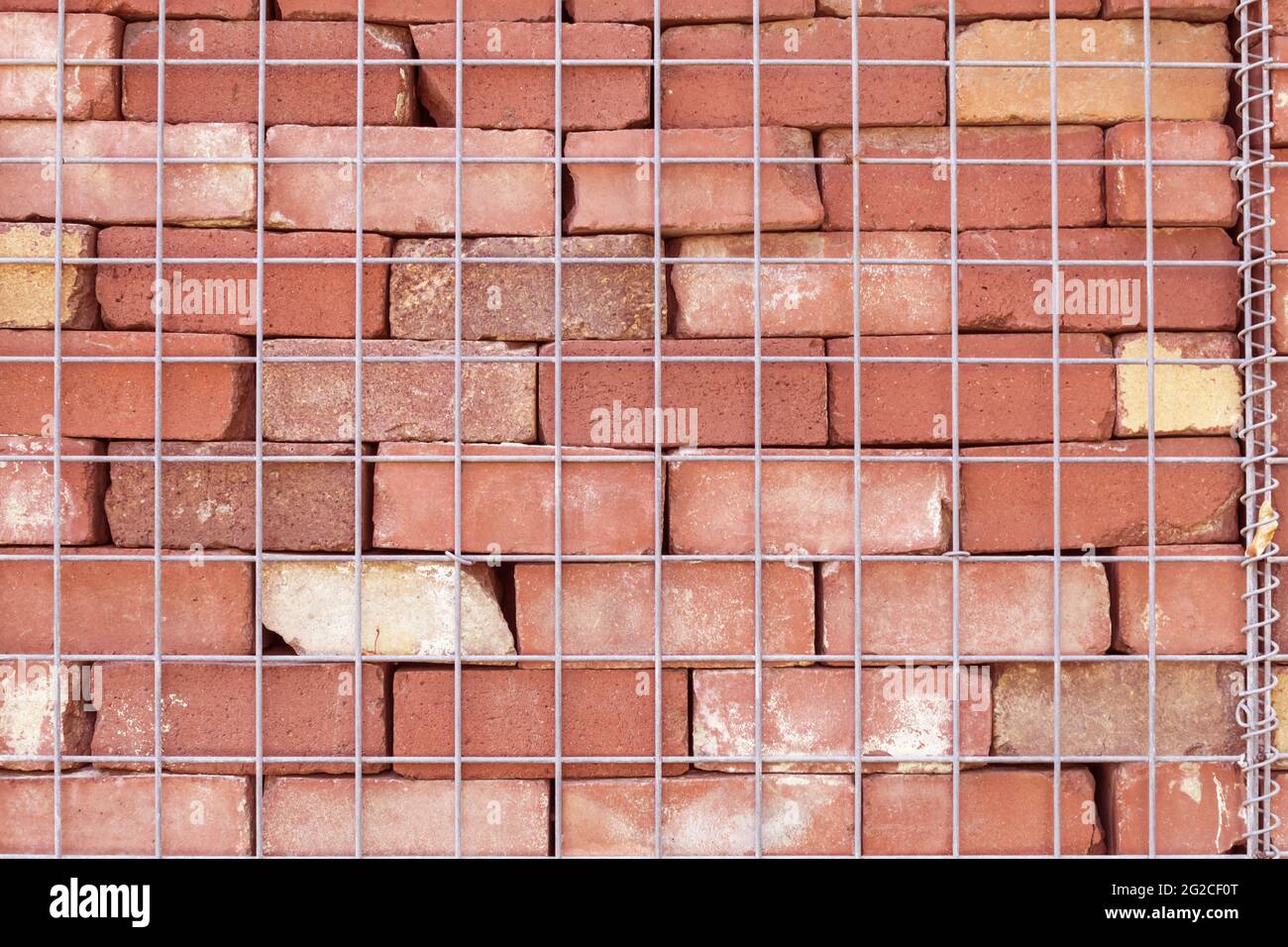 Fragment of a brick wall with a metal mesh. Texture, wall, stone ...