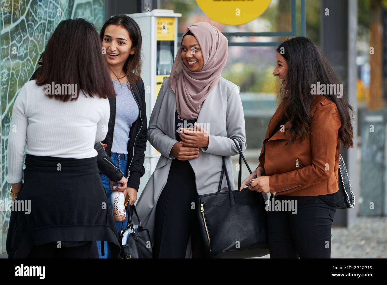 Smiling female friends talking together Stock Photo - Alamy