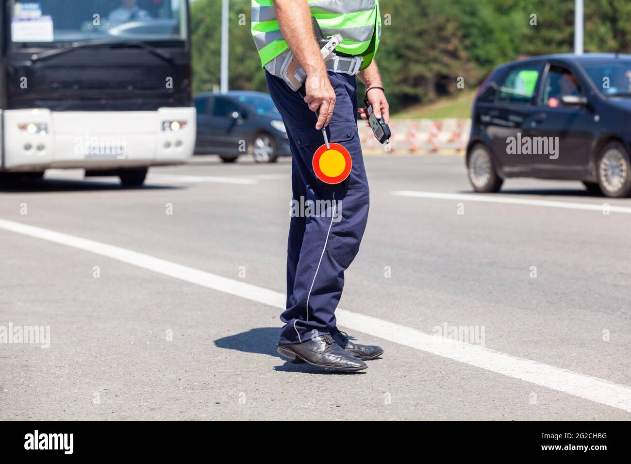 Policeman controlling traffic on the highway, bus and cars in the ...