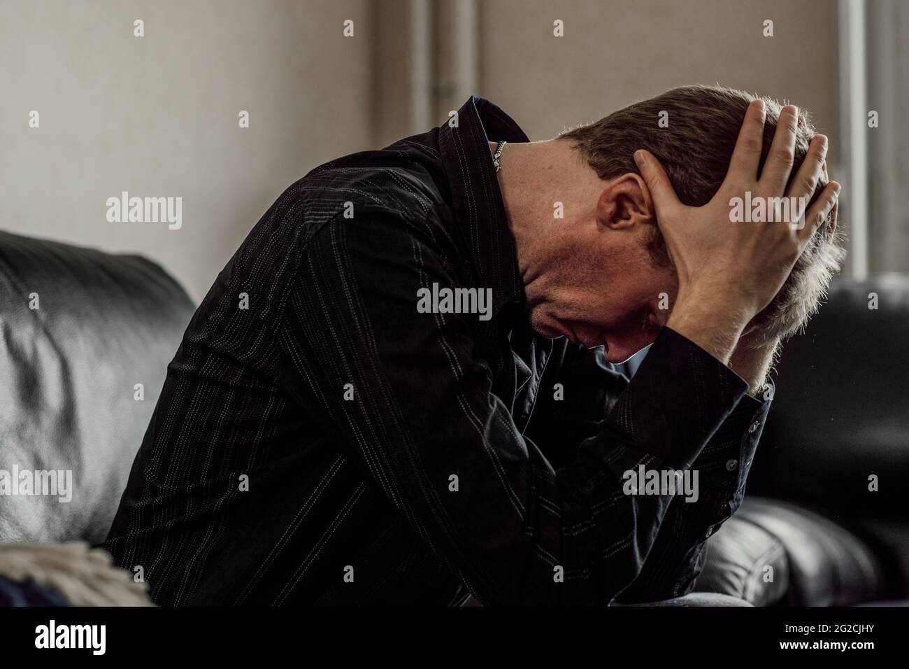 Man holding head in hands Stock Photo - Alamy