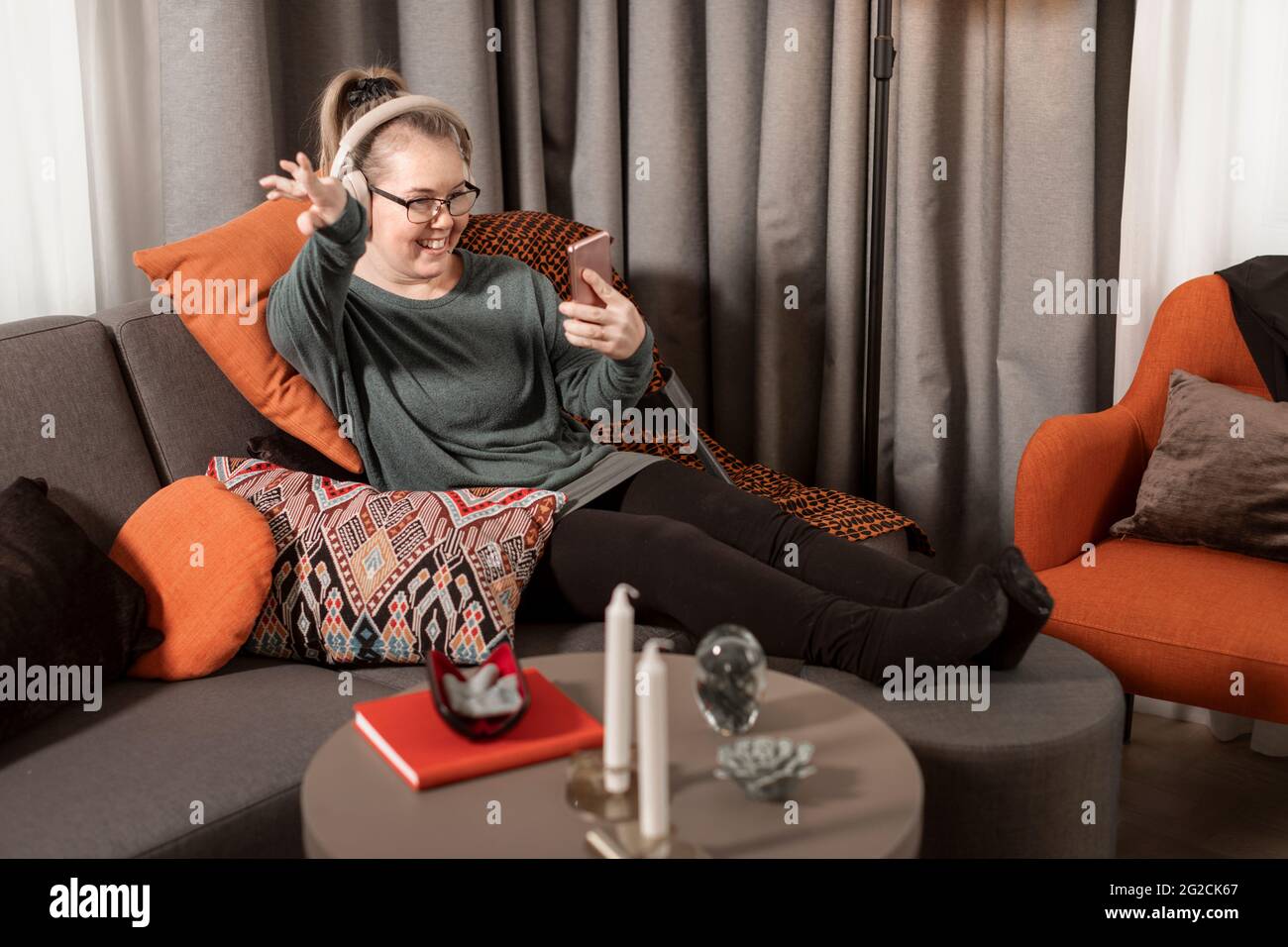 Smiling woman on sofa using cell phone Stock Photo - Alamy