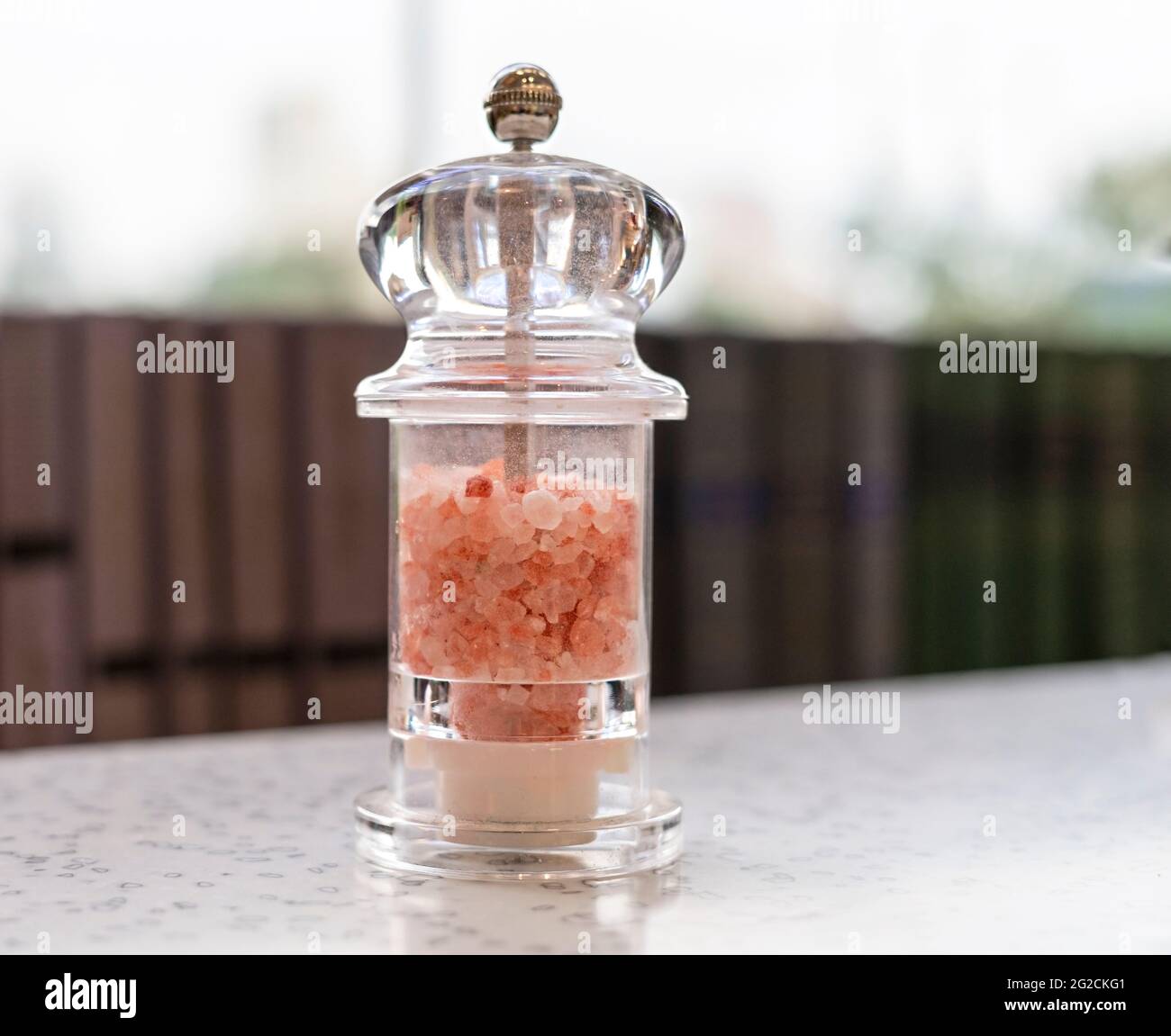 Himalayan pink salt in glass salt shaker close-up standing against the ...