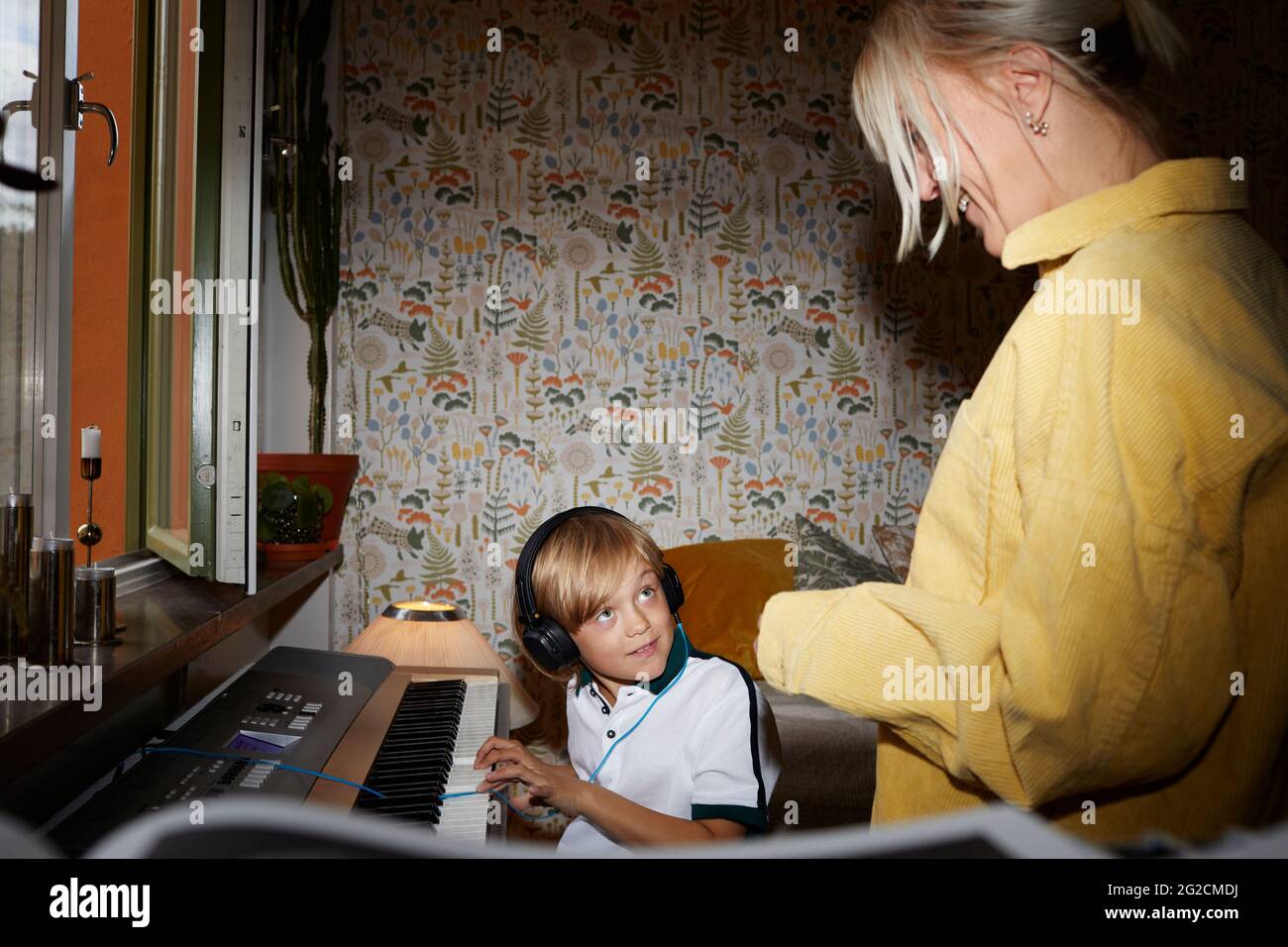 Mother talking with son playing keyboard Stock Photo - Alamy