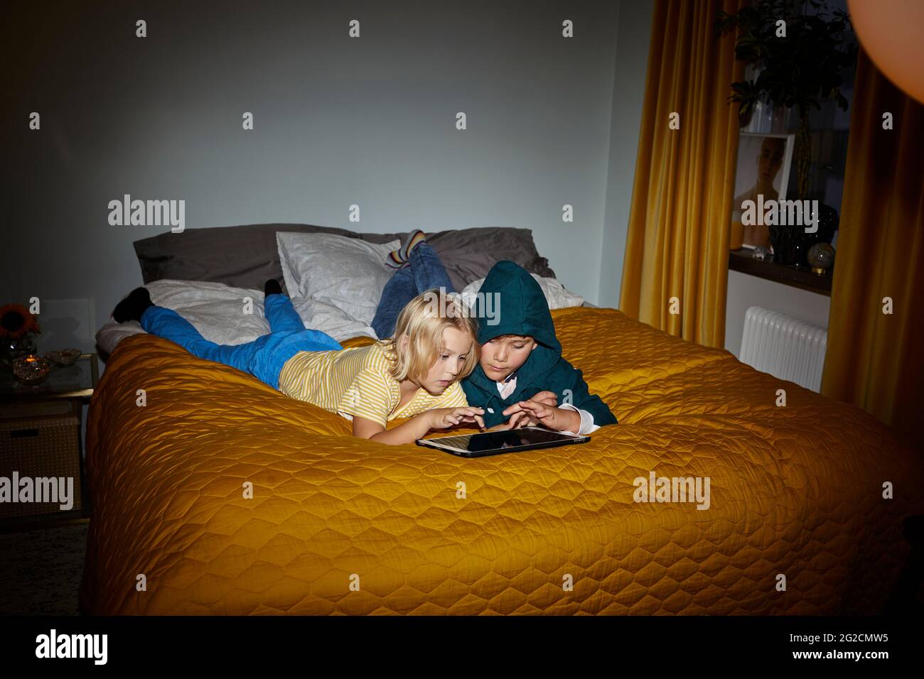 Boys using digital tablet on bed Stock Photo - Alamy