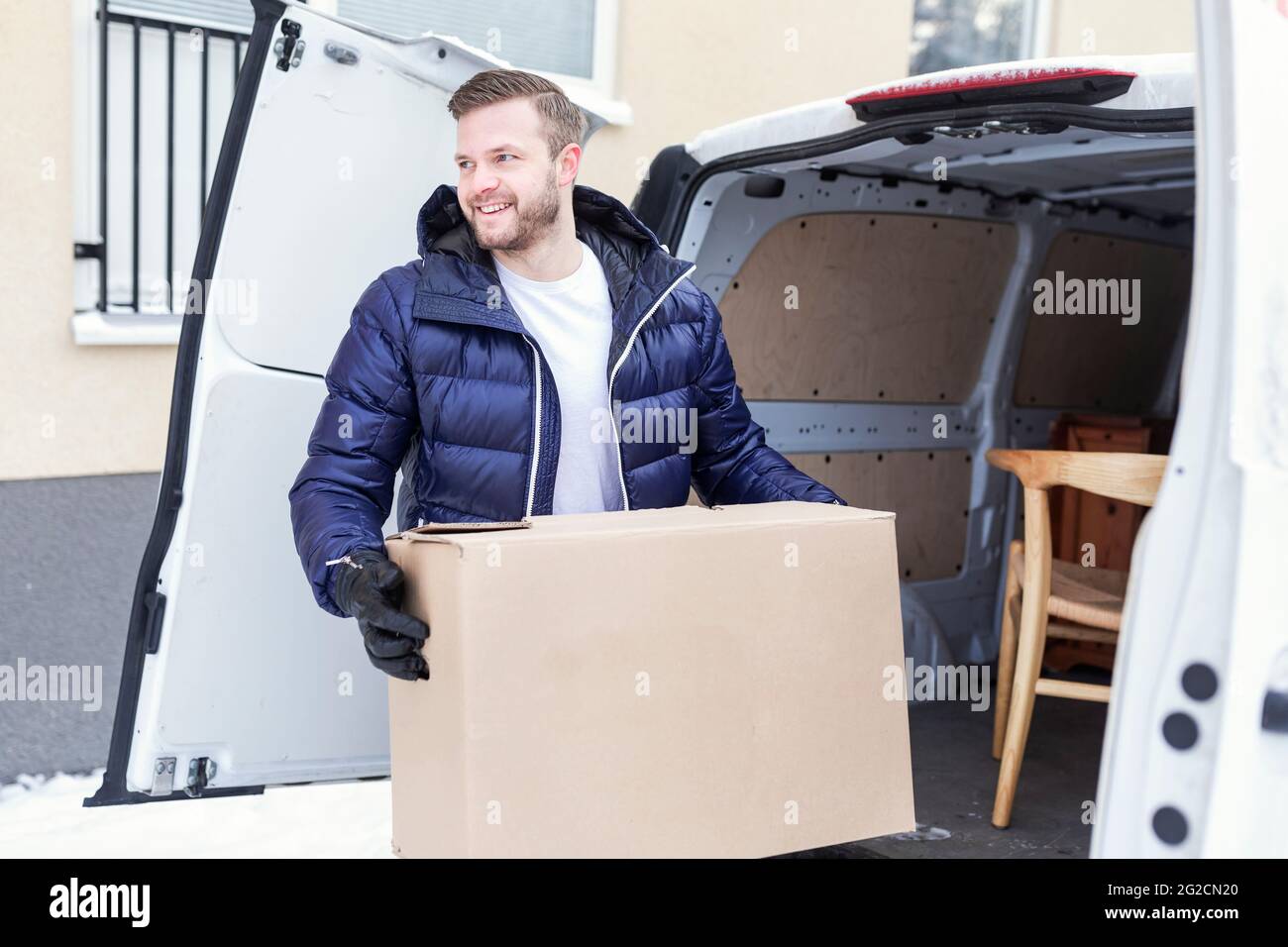 Smiling man carrying cardboard box Stock Photo - Alamy