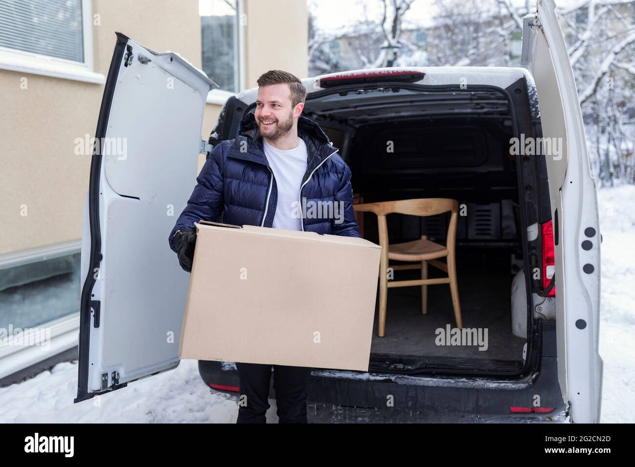 Smiling man carrying cardboard box Stock Photo - Alamy