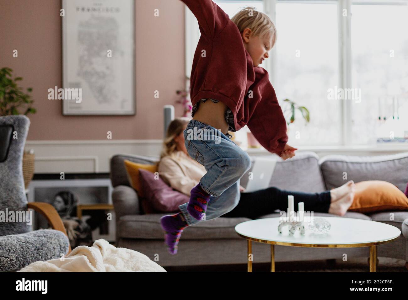 Boy jumping in living room Stock Photo - Alamy